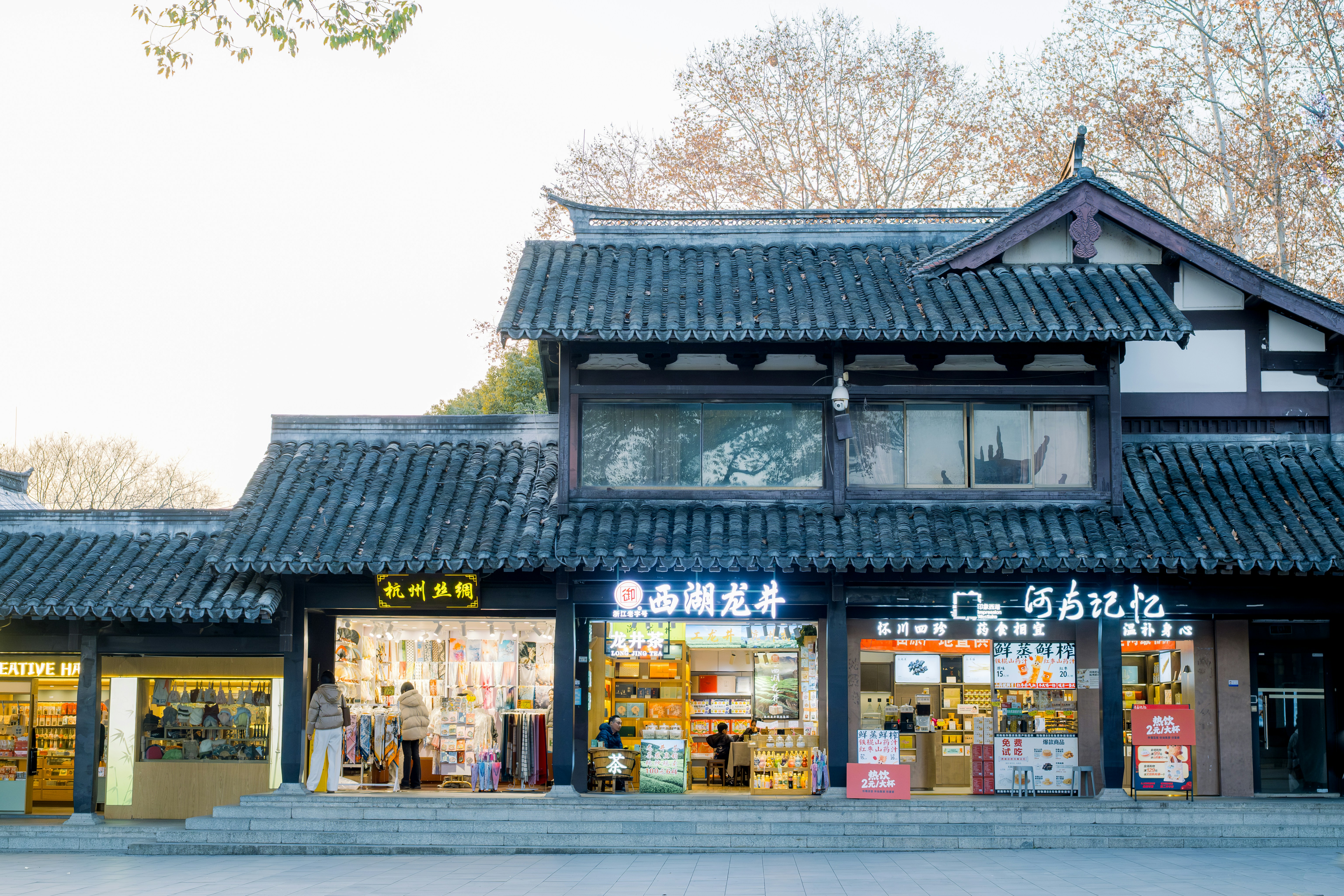 Traditional storefronts under a tiled roofline: a quiet riverside street scene