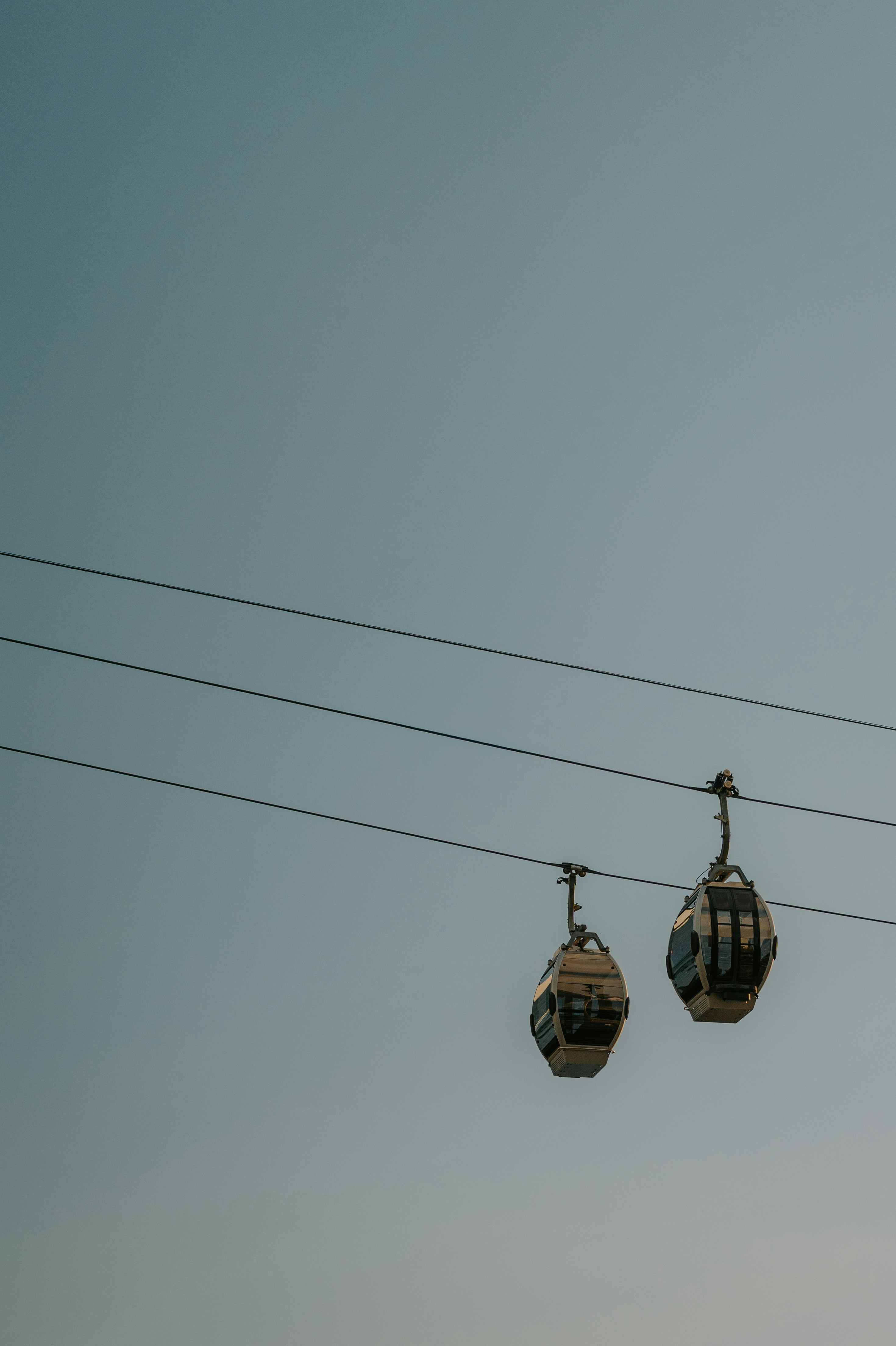 Cable Car in Quiet Skies: A Minimalist Lift Across a Dawn-Blue Span