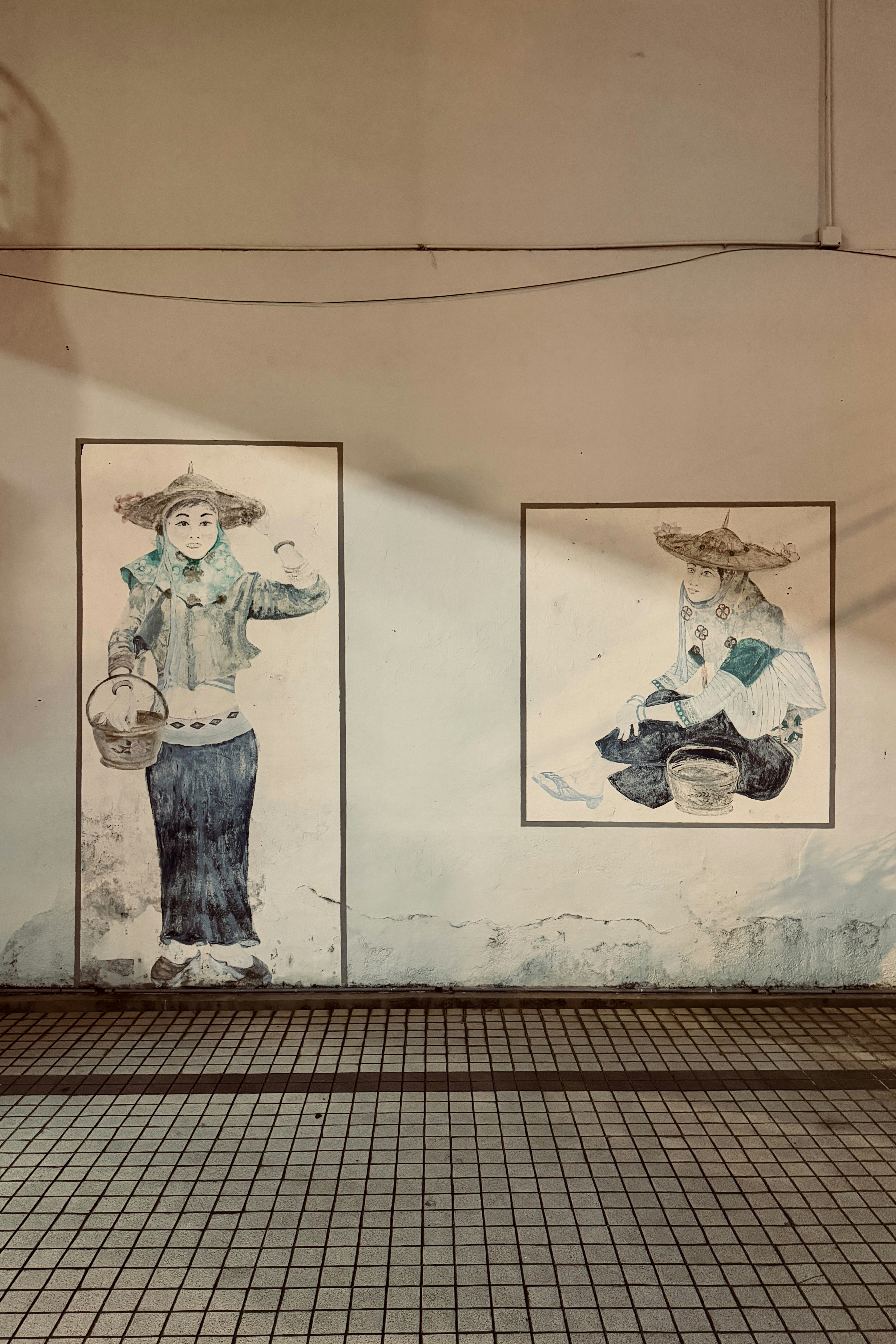 Mural Figures: A Street Scene of Painted Vendors on a Shaded Wall