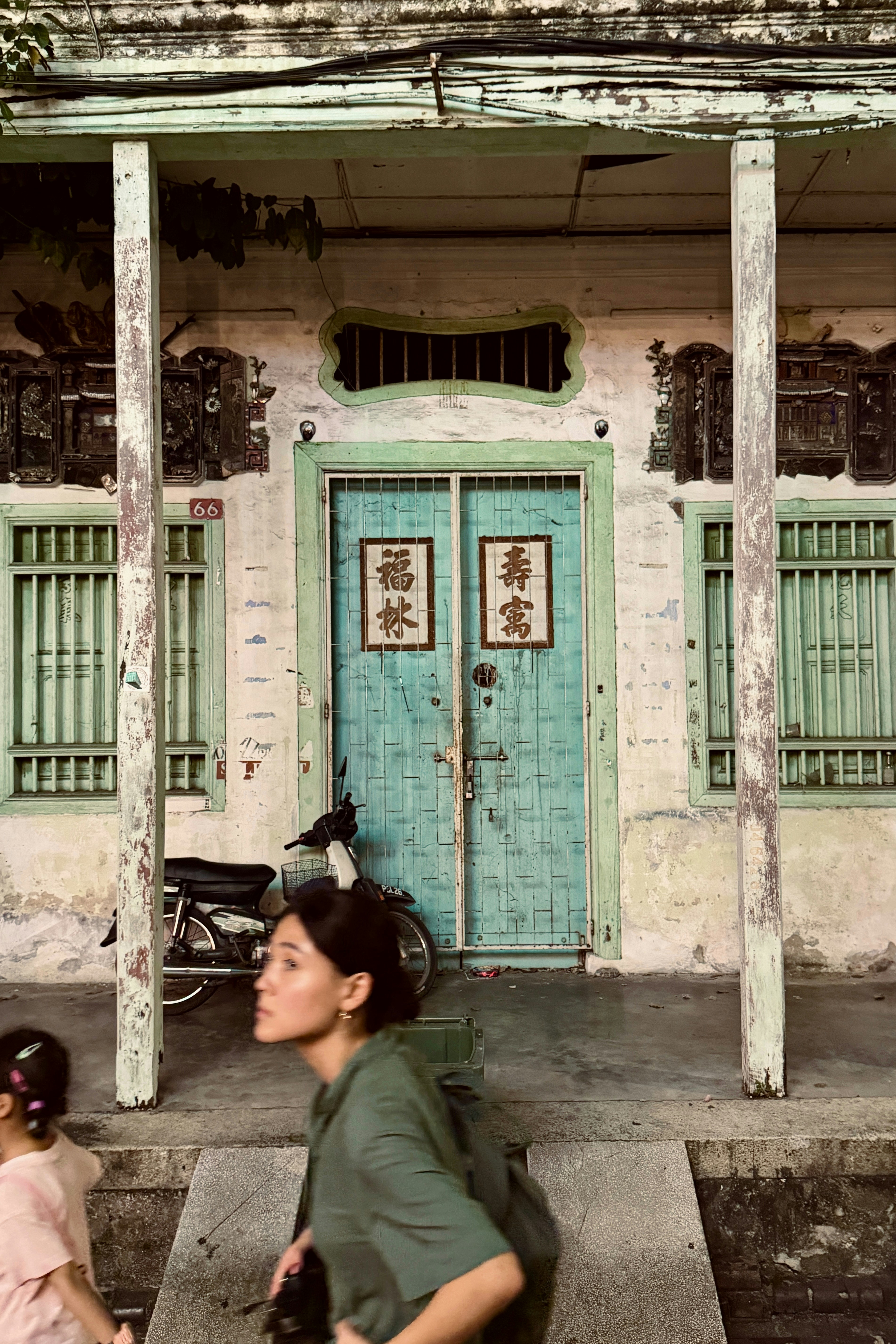 Blue Door Under Balcony: A Street Scene Framed by Weathered Columns