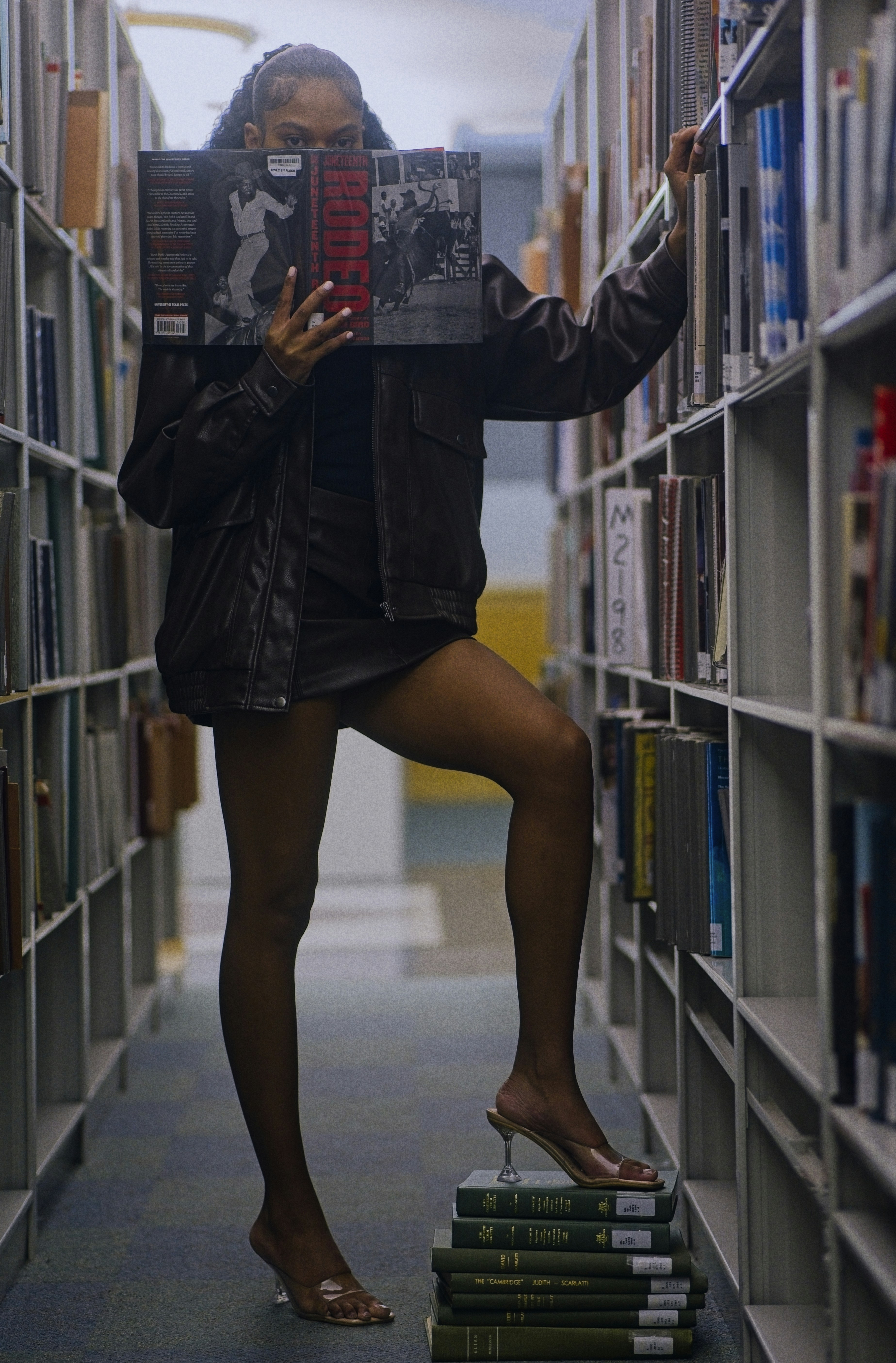Under Library Glow: A Poised Reader Balances on Books