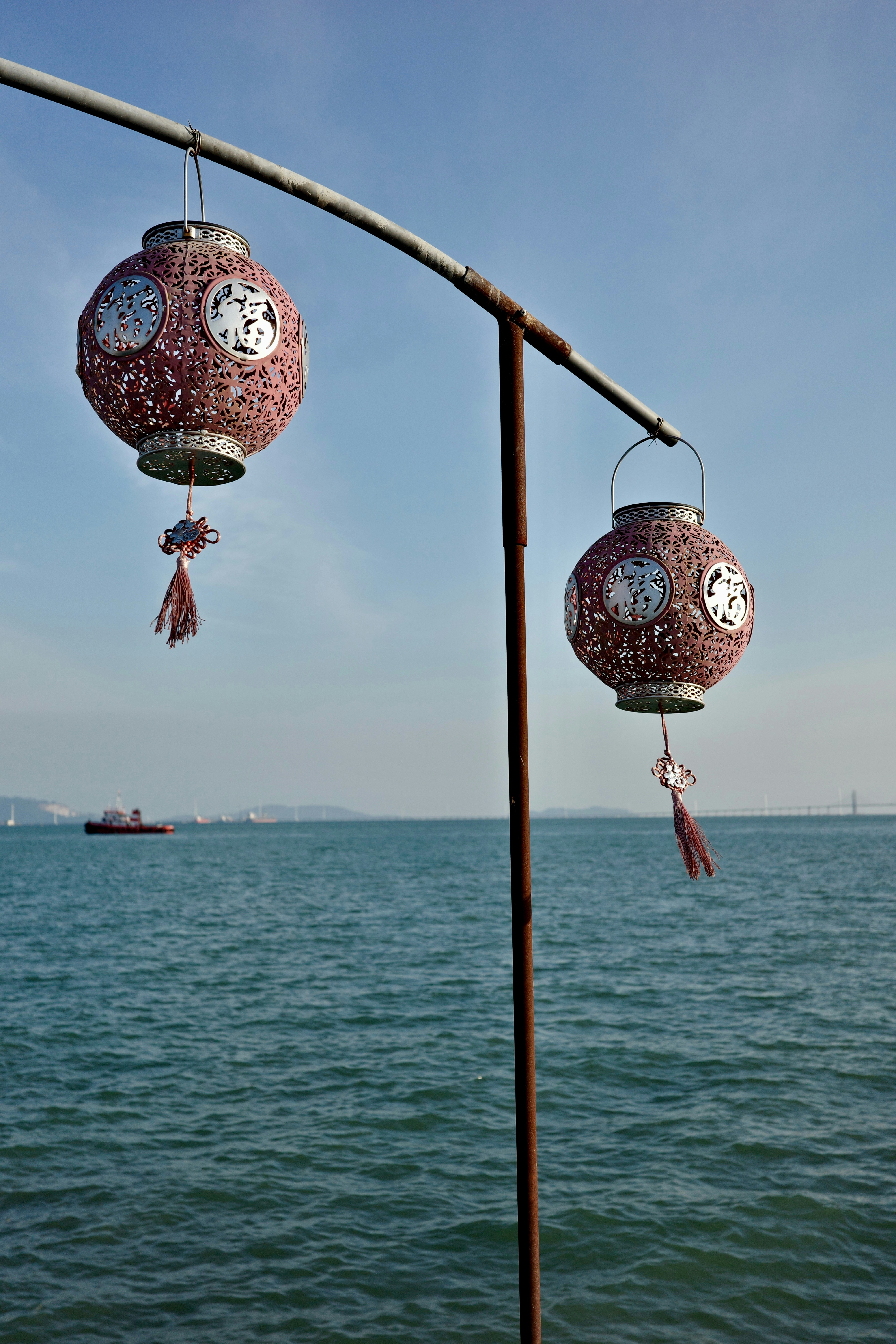 Two Lantern Orbs Over Sea: A Quiet Harbor at Dusk