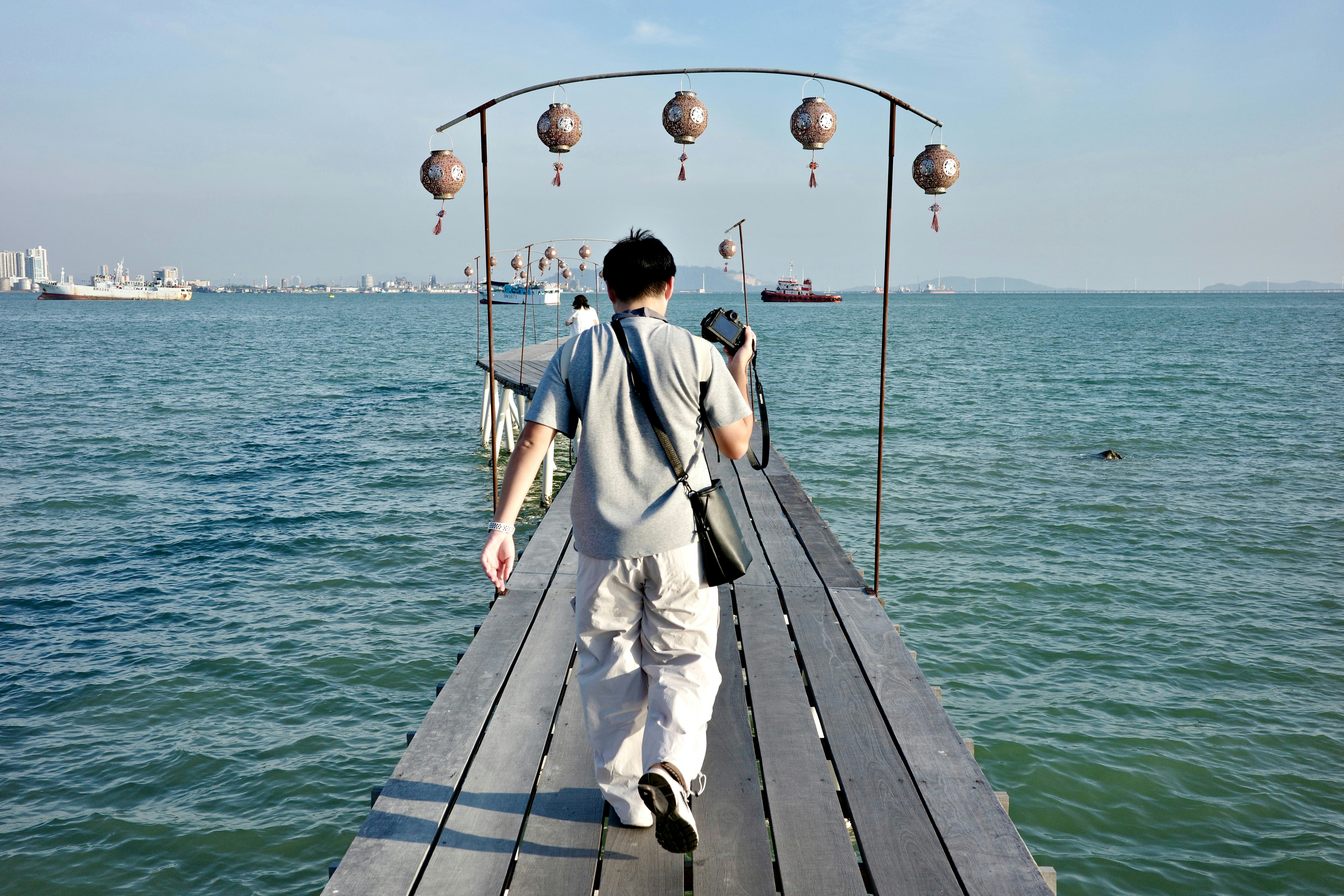 Traveler on a Seaside Pier: A Quiet Walk Toward the Horizon