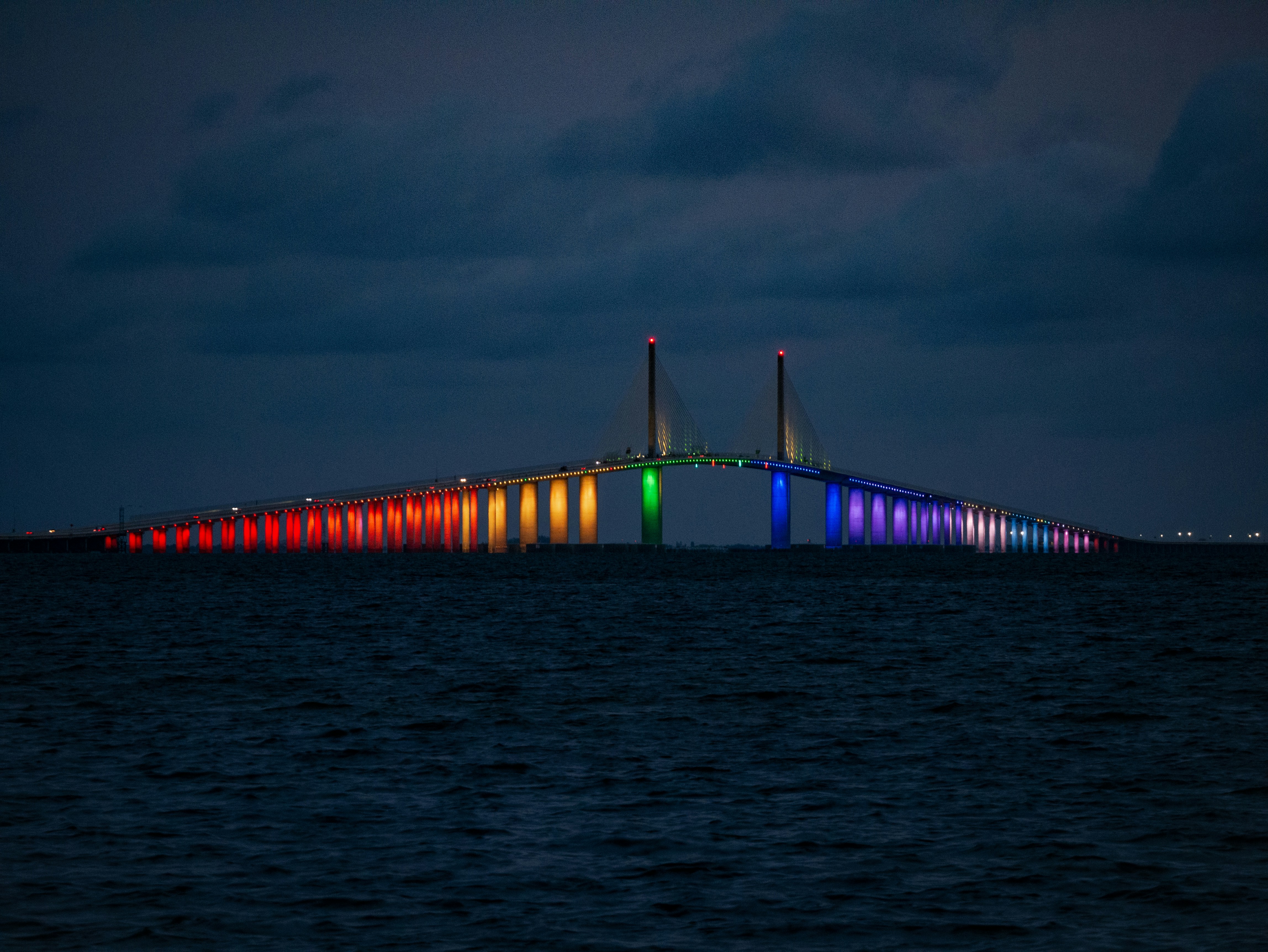 Rainbow Span: A Nighttime Lightbridge over Quiet Waters
