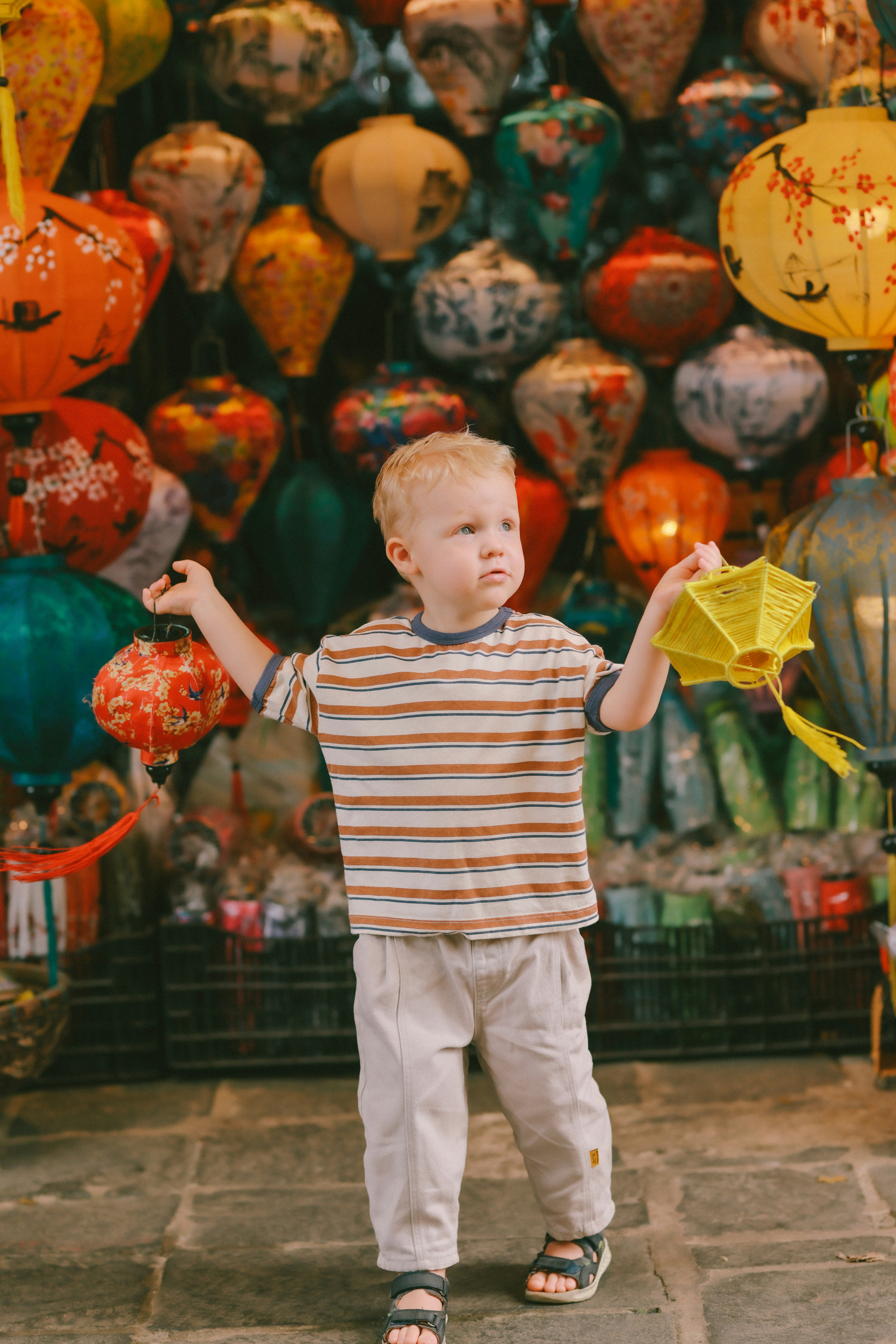 Kid with Lanterns: A Moment of Wonder Among Floating Colors