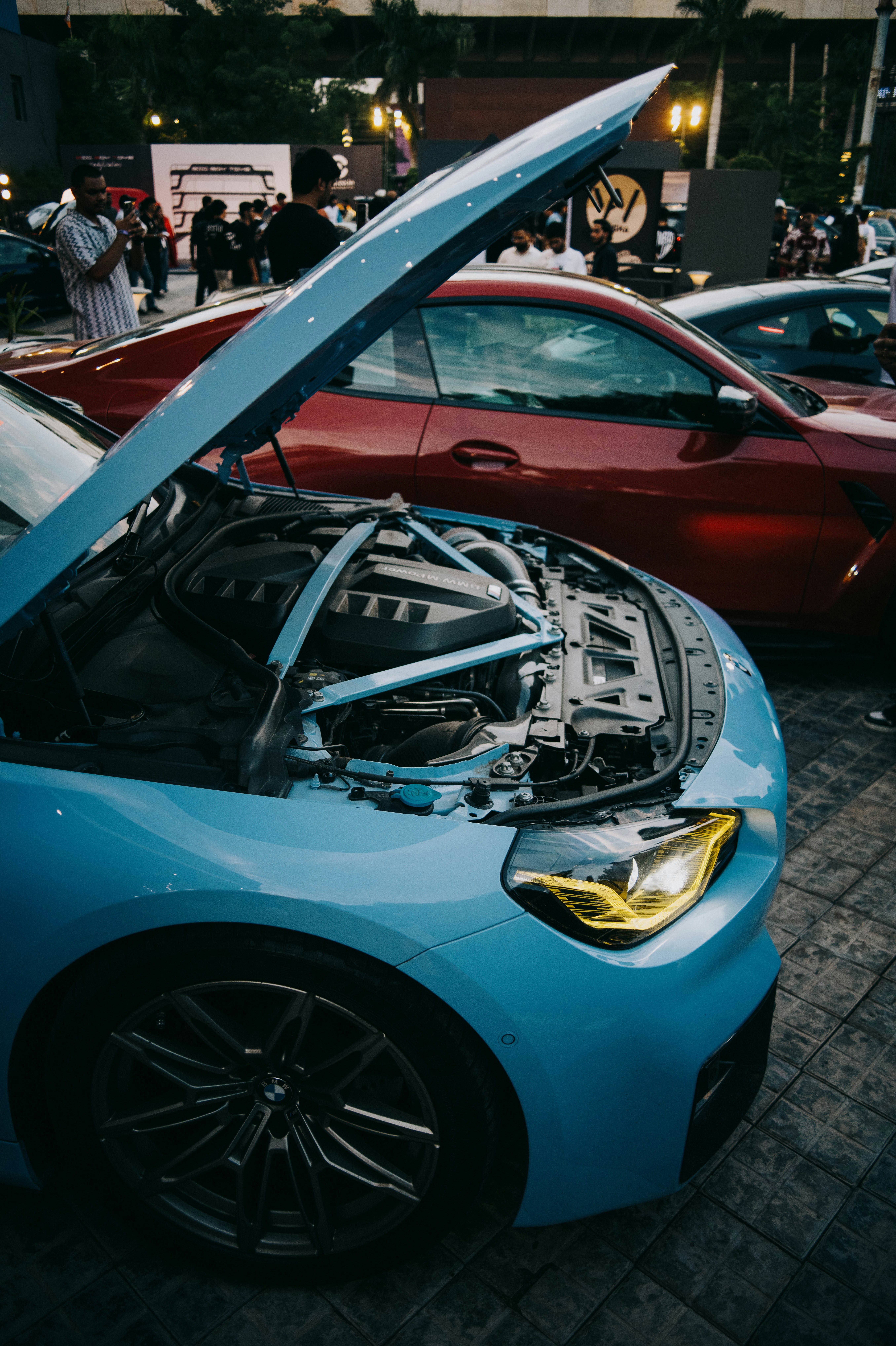 Light blue car with hood open revealing engine
