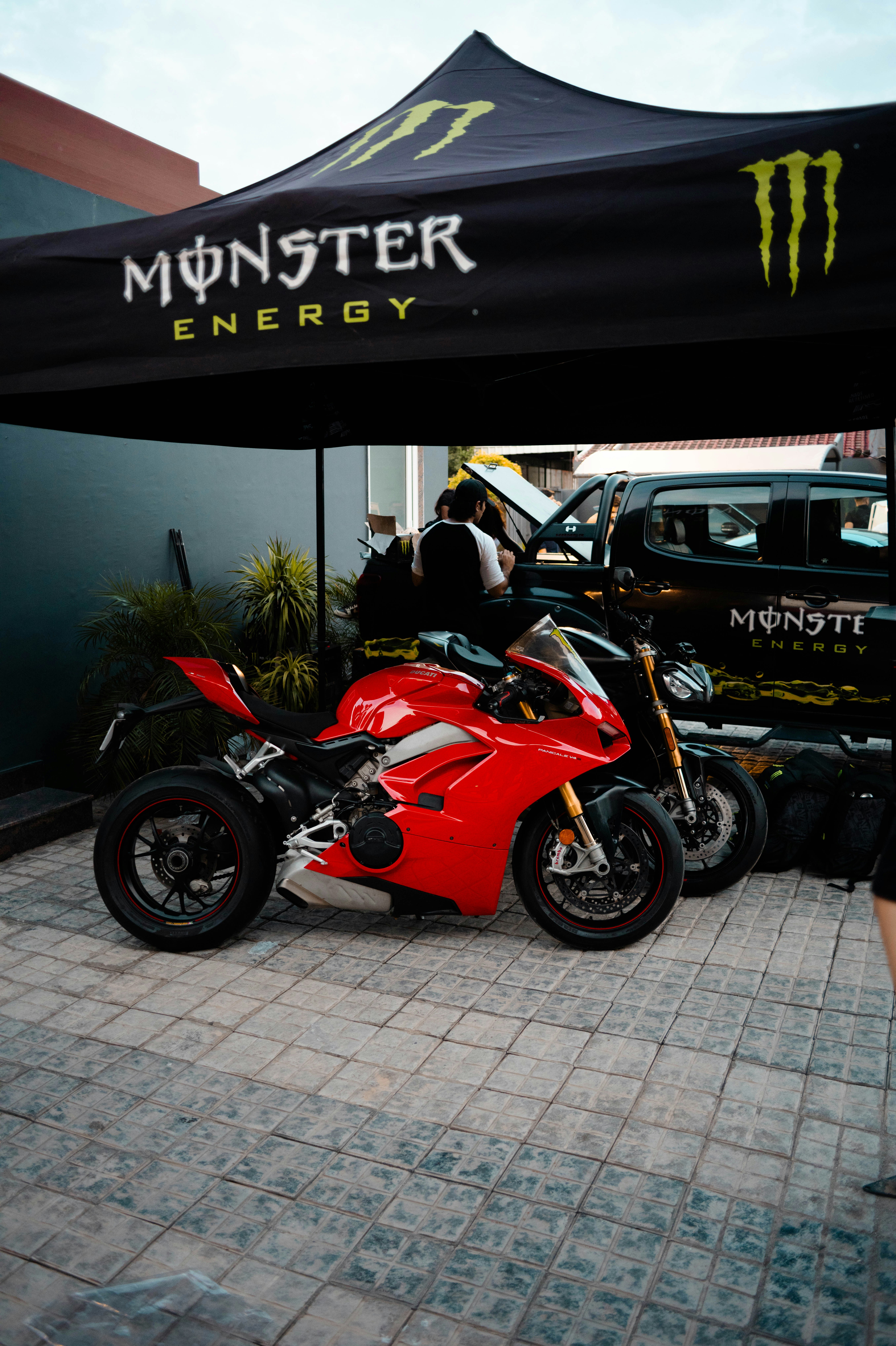 Red sport motorcycle parked under monster energy tent