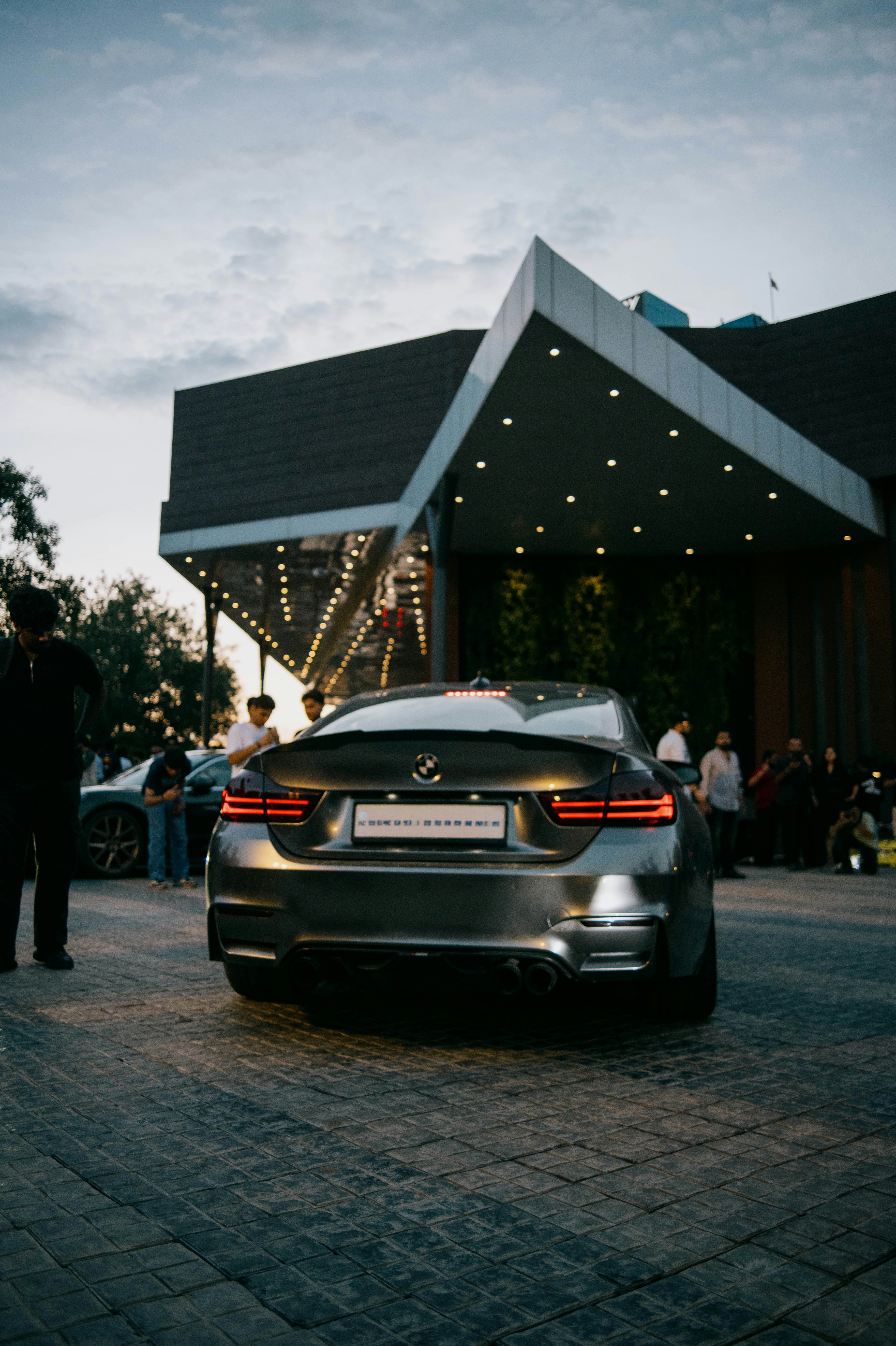 A sleek, modern car parked outside a building at dusk.