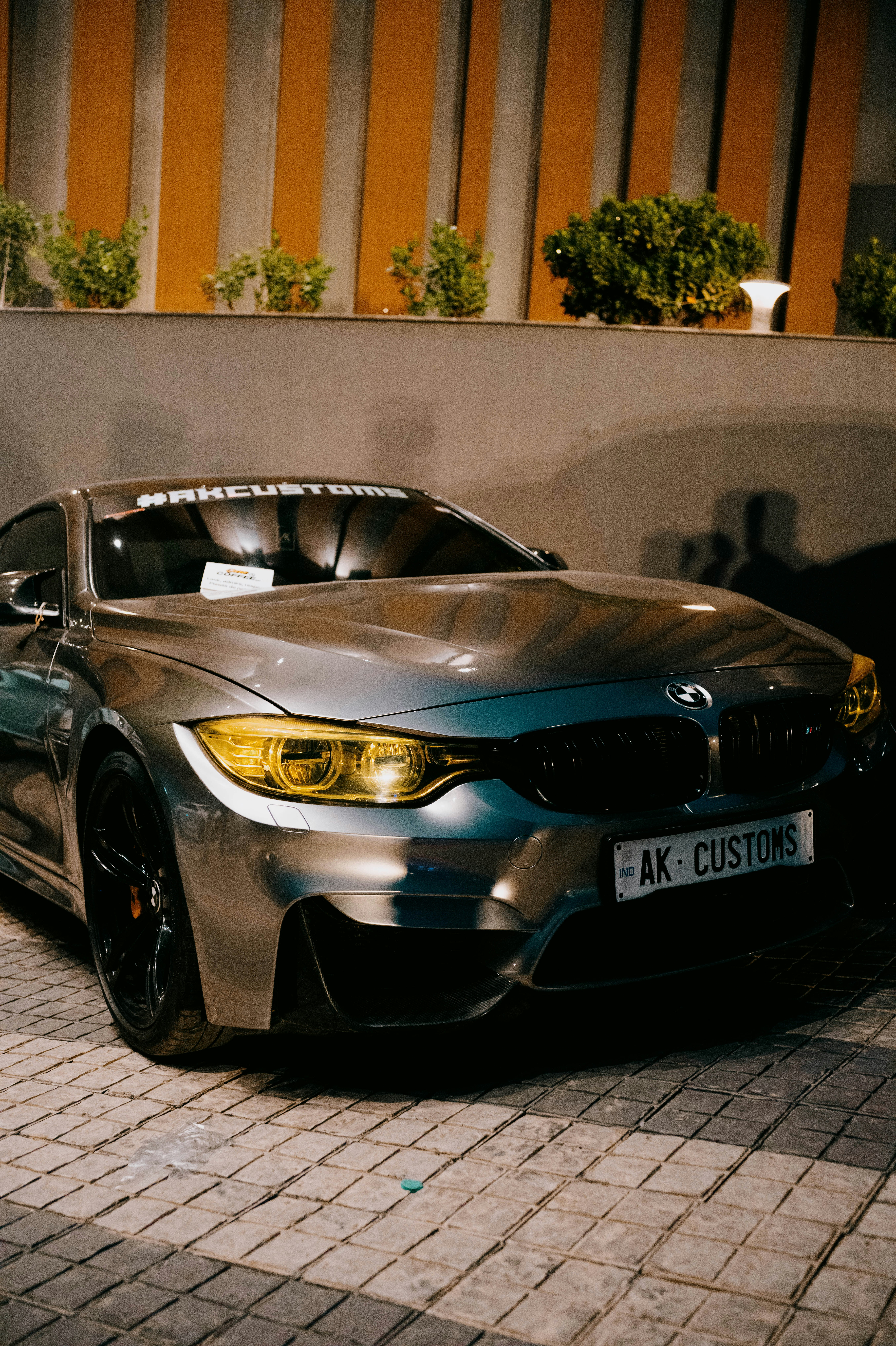 A sleek silver BMW with yellow headlights