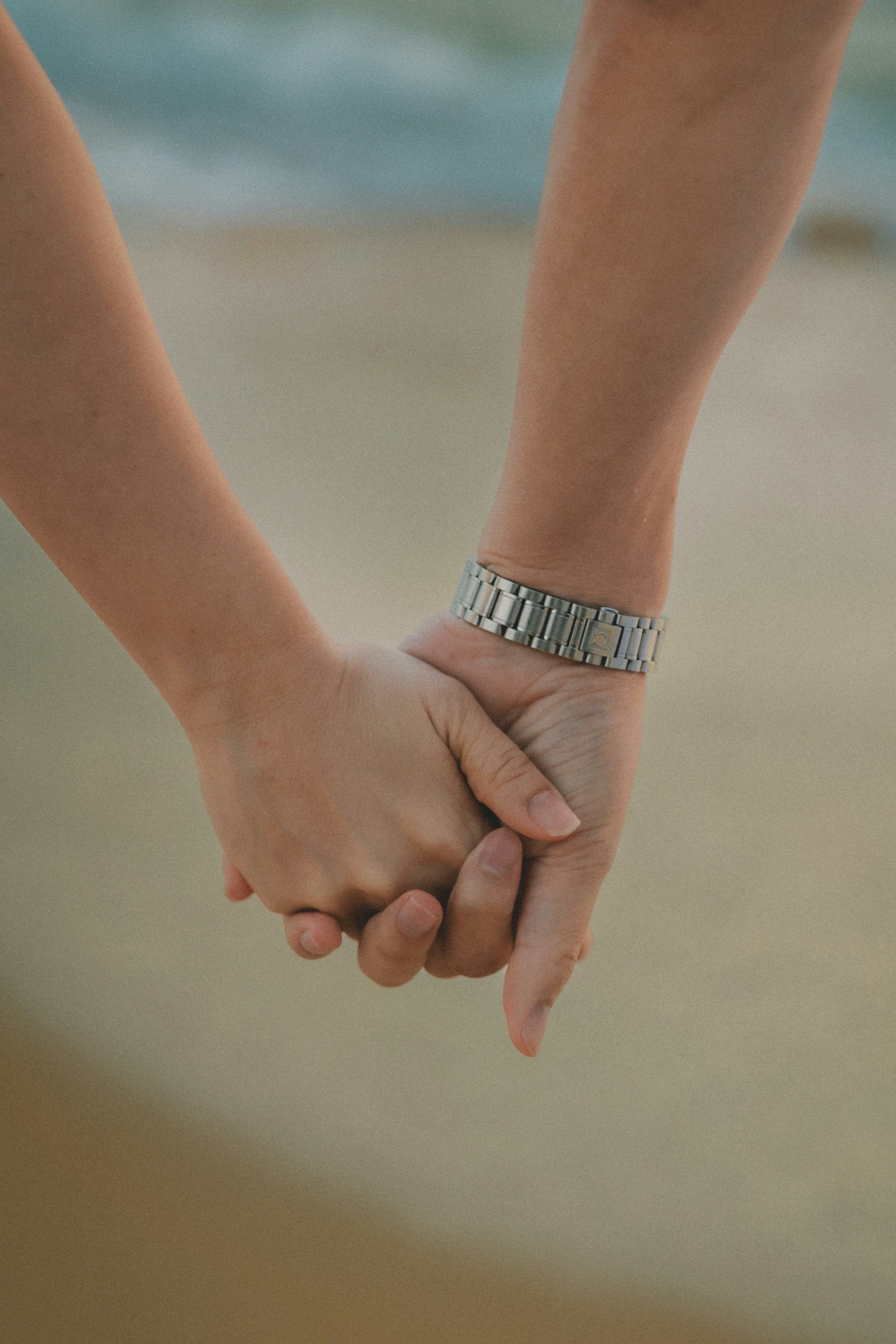 Holding On Together: intimate clasp at the shore