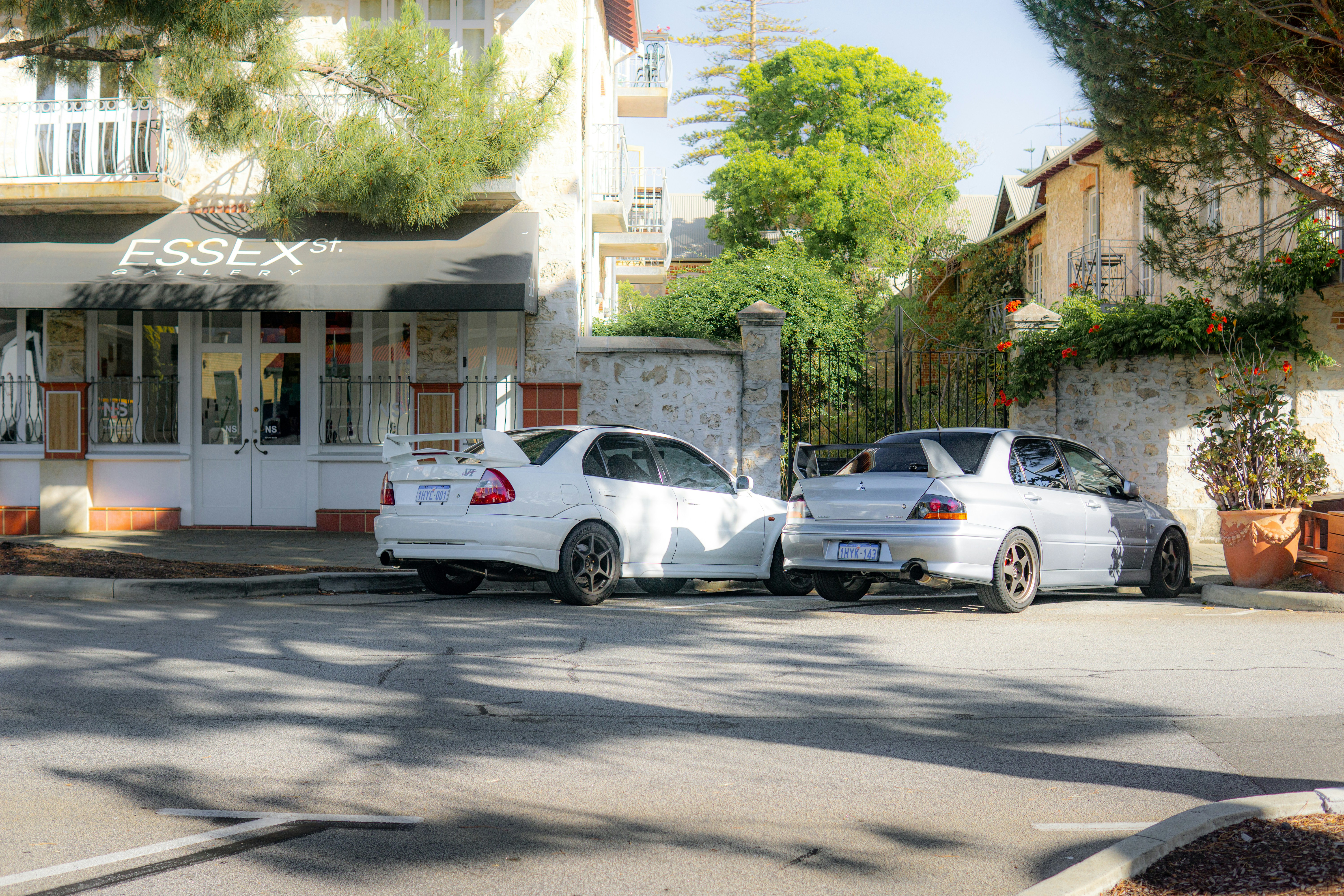 Quiet Mediterranean Street: Cars Parked by a Café
