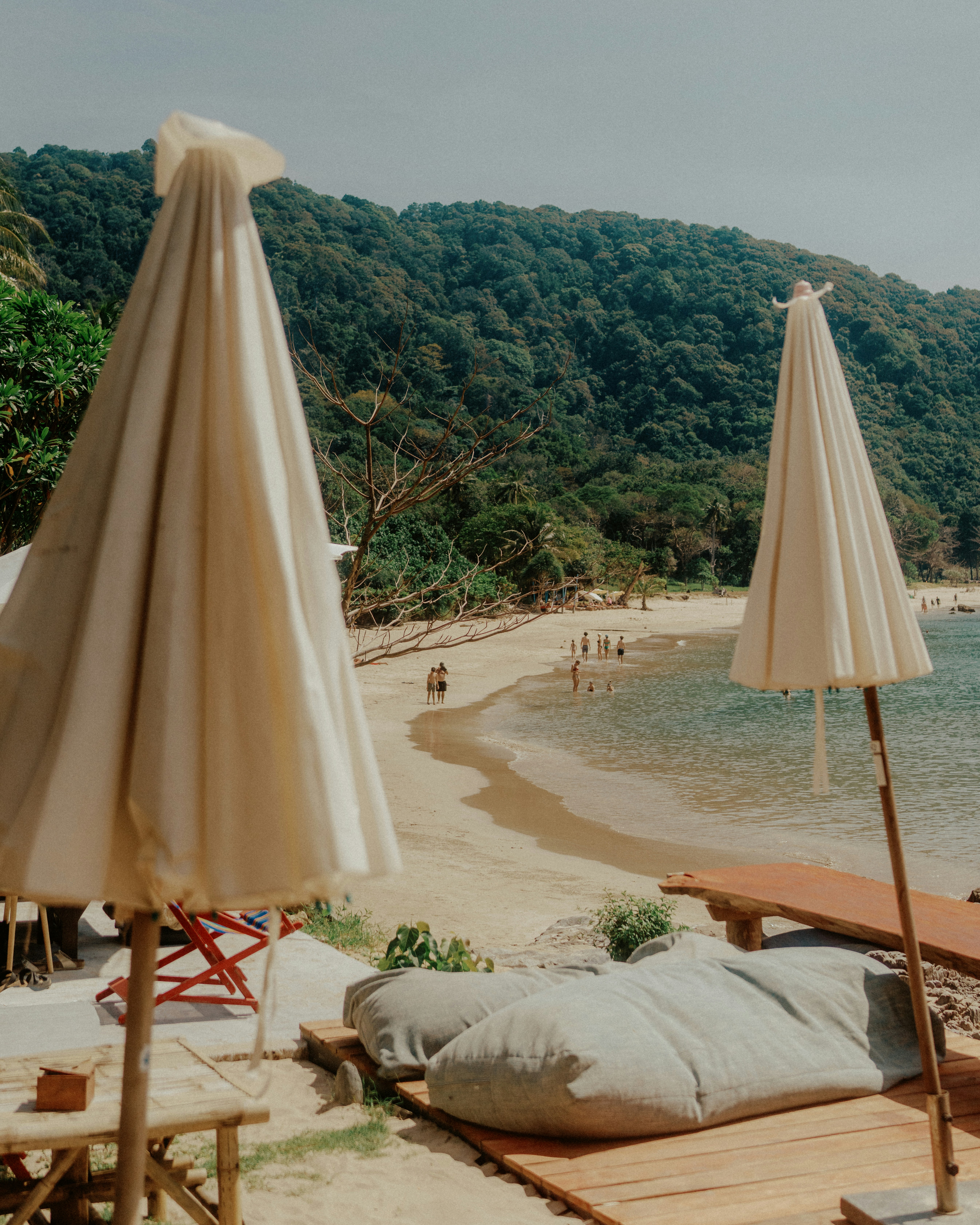 Sunlit Beach Lounge under Tented Umbrellas in Calm Seaside Resort