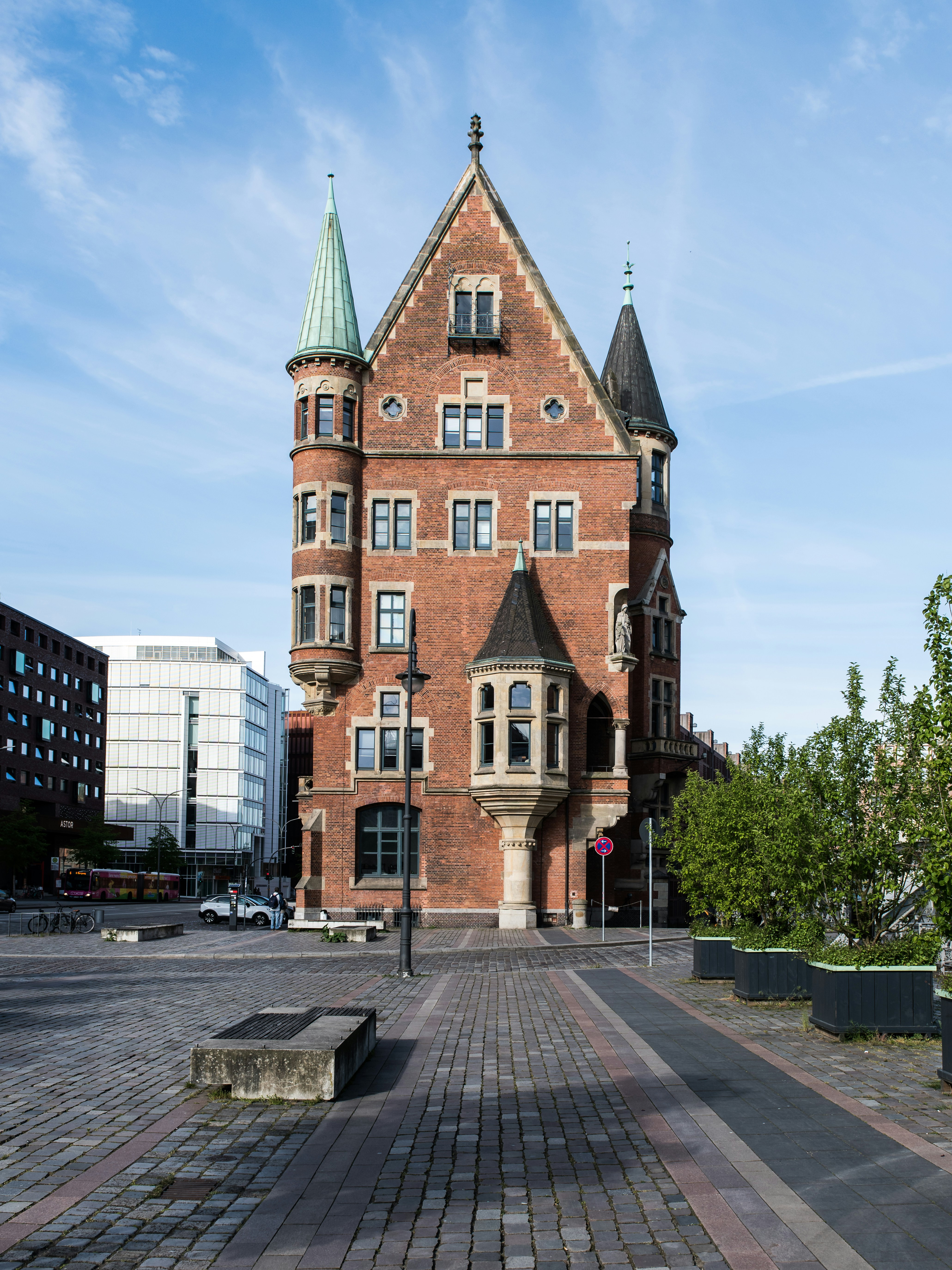 Red Brick Turreted Castle: A City Landmark Rising Over Cobbled Square