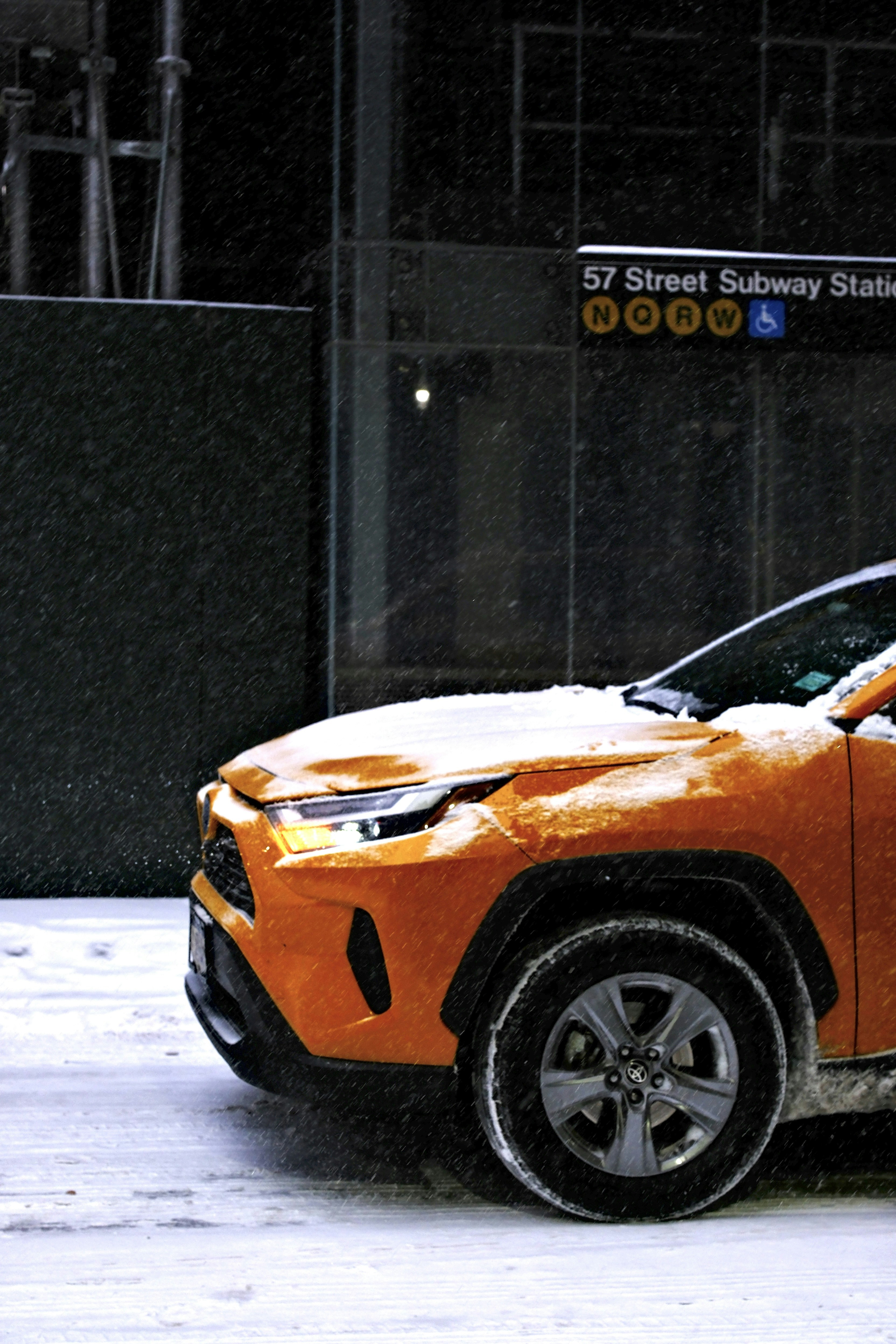 Orange SUV Emerges from Snowy Street with Bold Stance