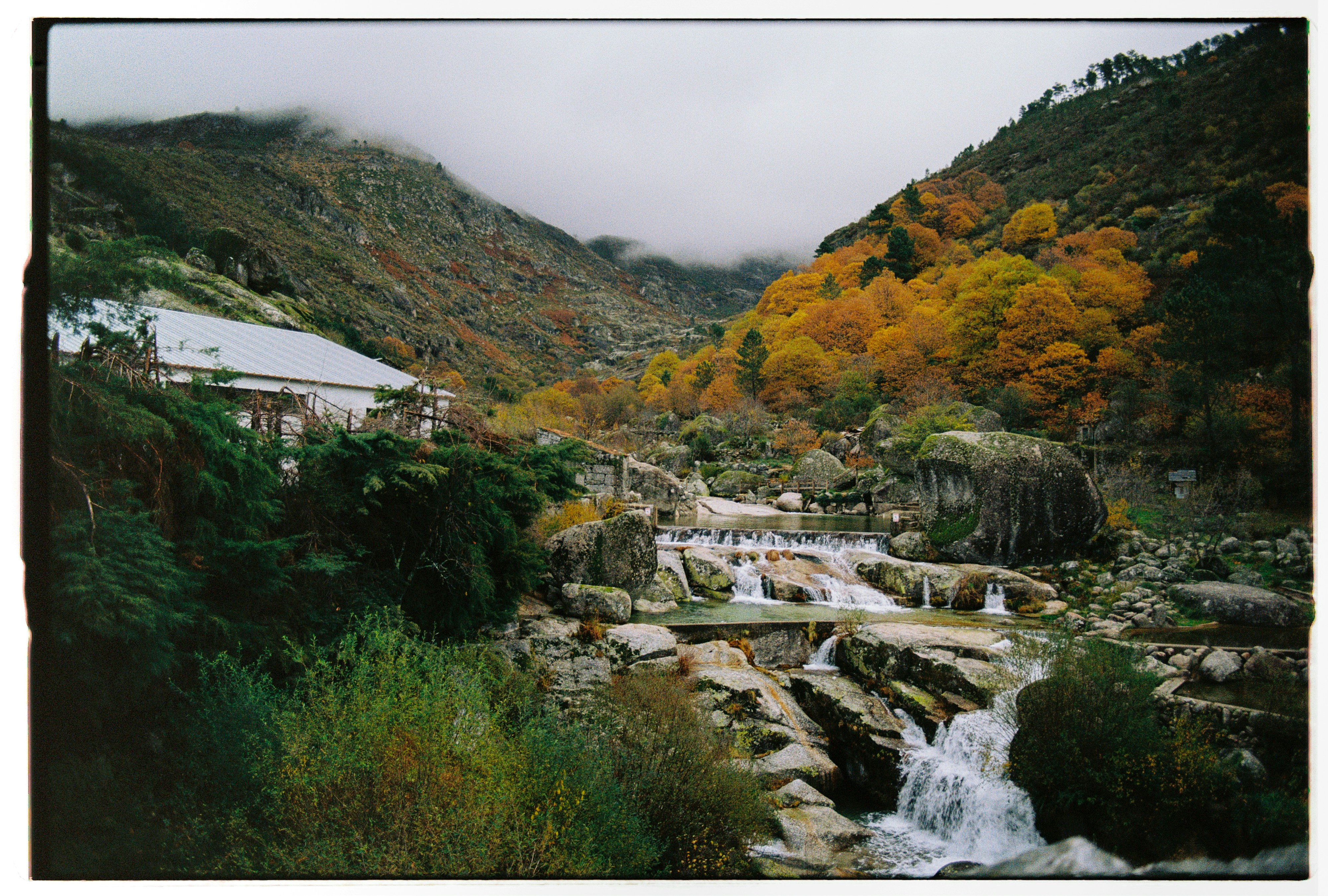 Autumn River cascade beneath misty mountains