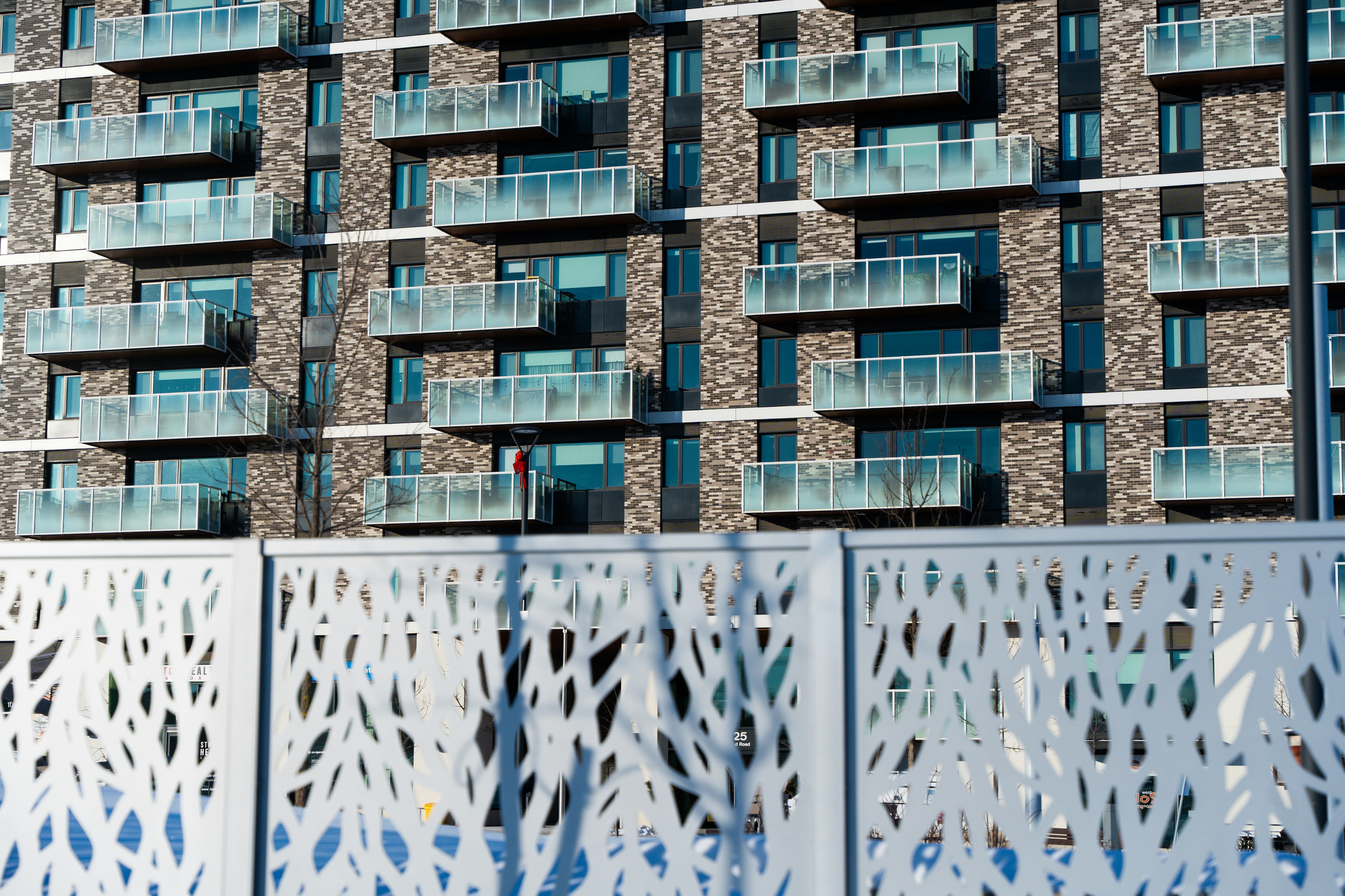 Patterned Balcony Grid Over a Modern Brick Facade