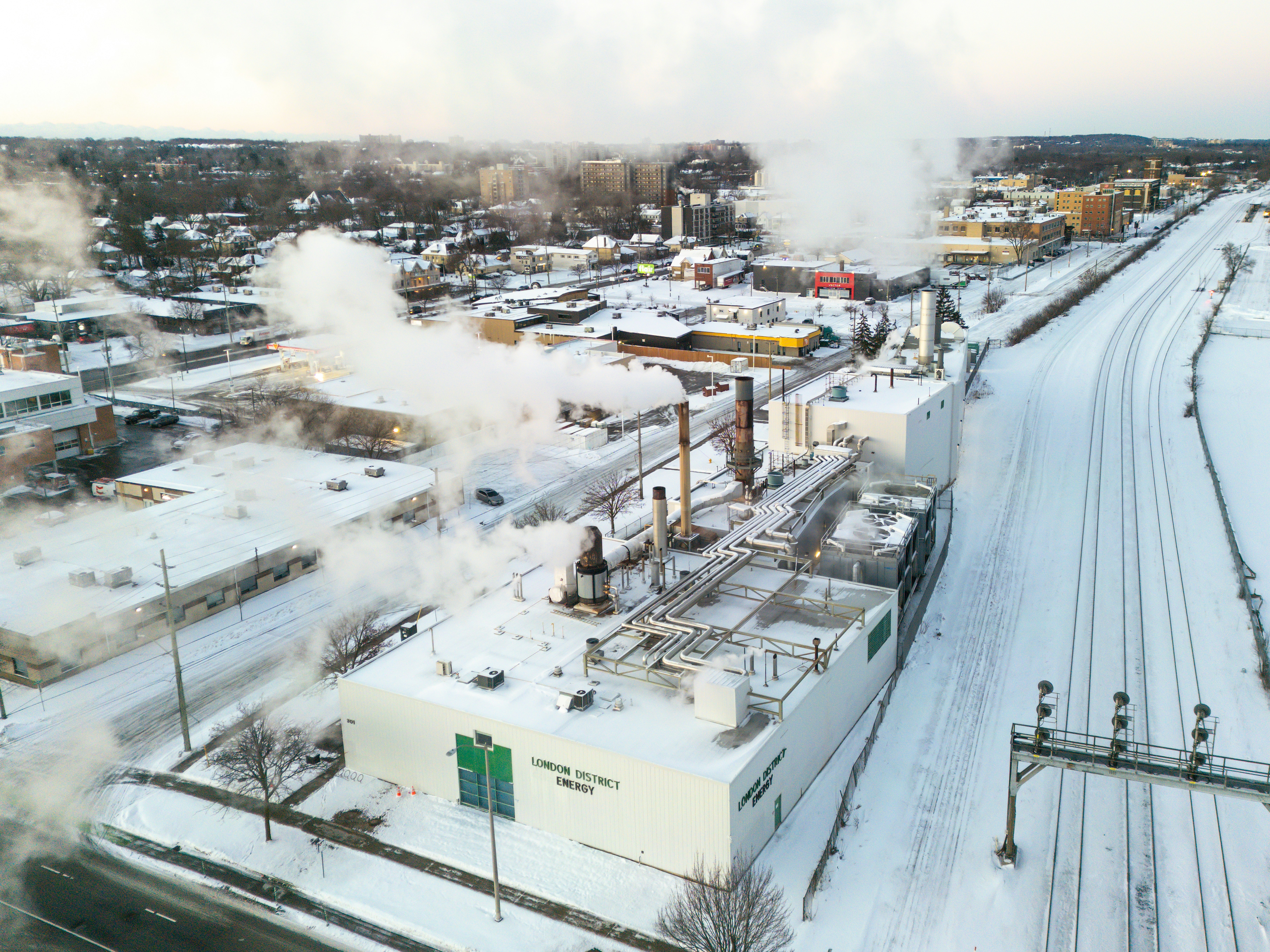Industrial plume: steam and snow over a cold utility complex