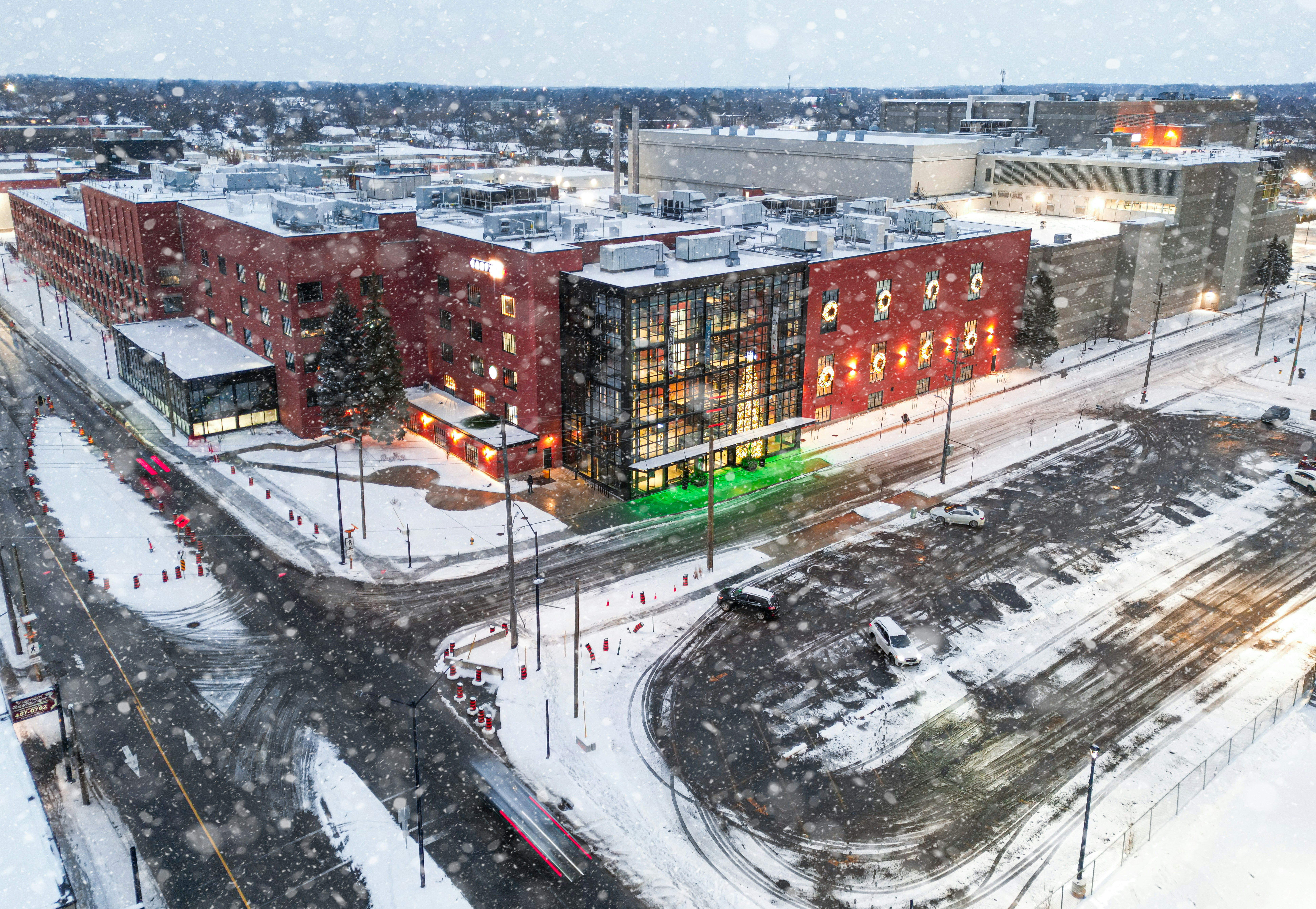 Snowy Campus Bloc: Aerial View of Modern Red Brick Building at Dusk Snowfall