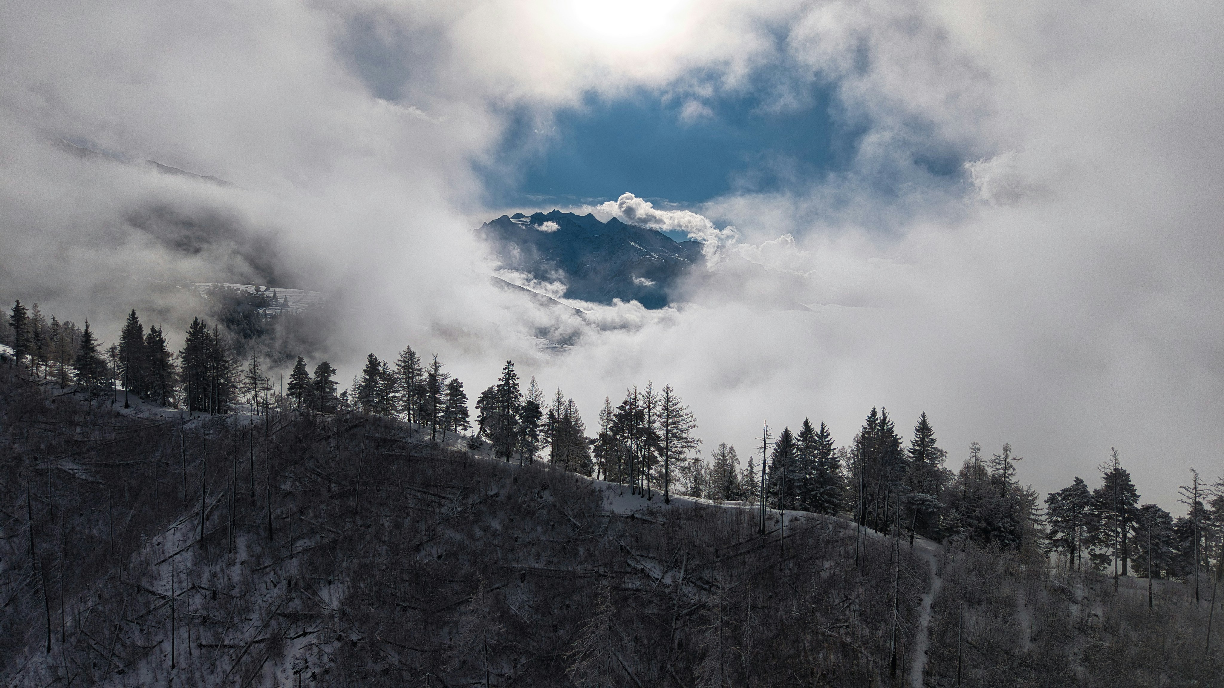 Mist-veiled Peaks: A Snowy Ridge Beneath Opening Skies