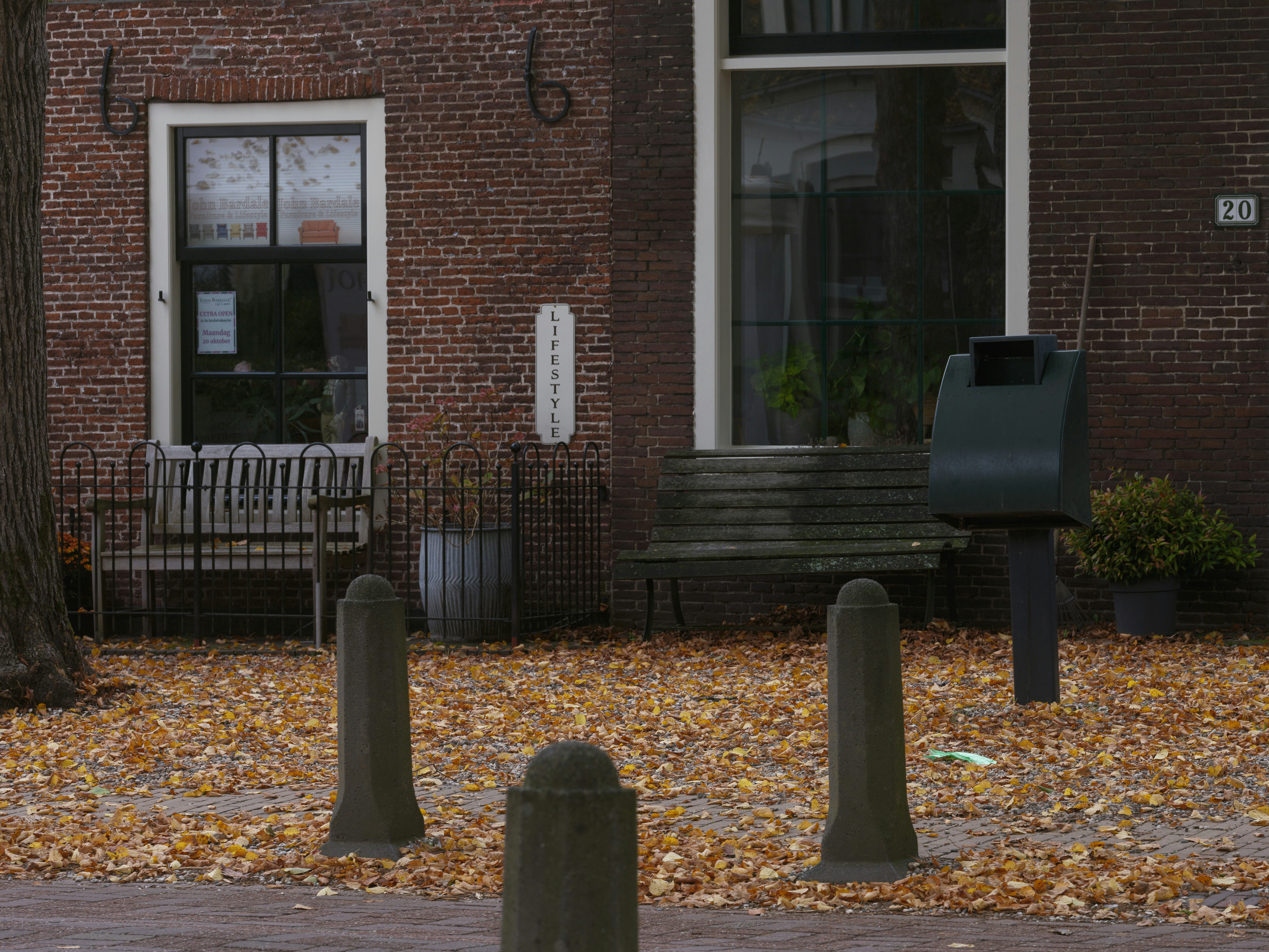 Autumn Quiet: Leaves Blanketing a Brick Courtyard by a Quiet Doorway