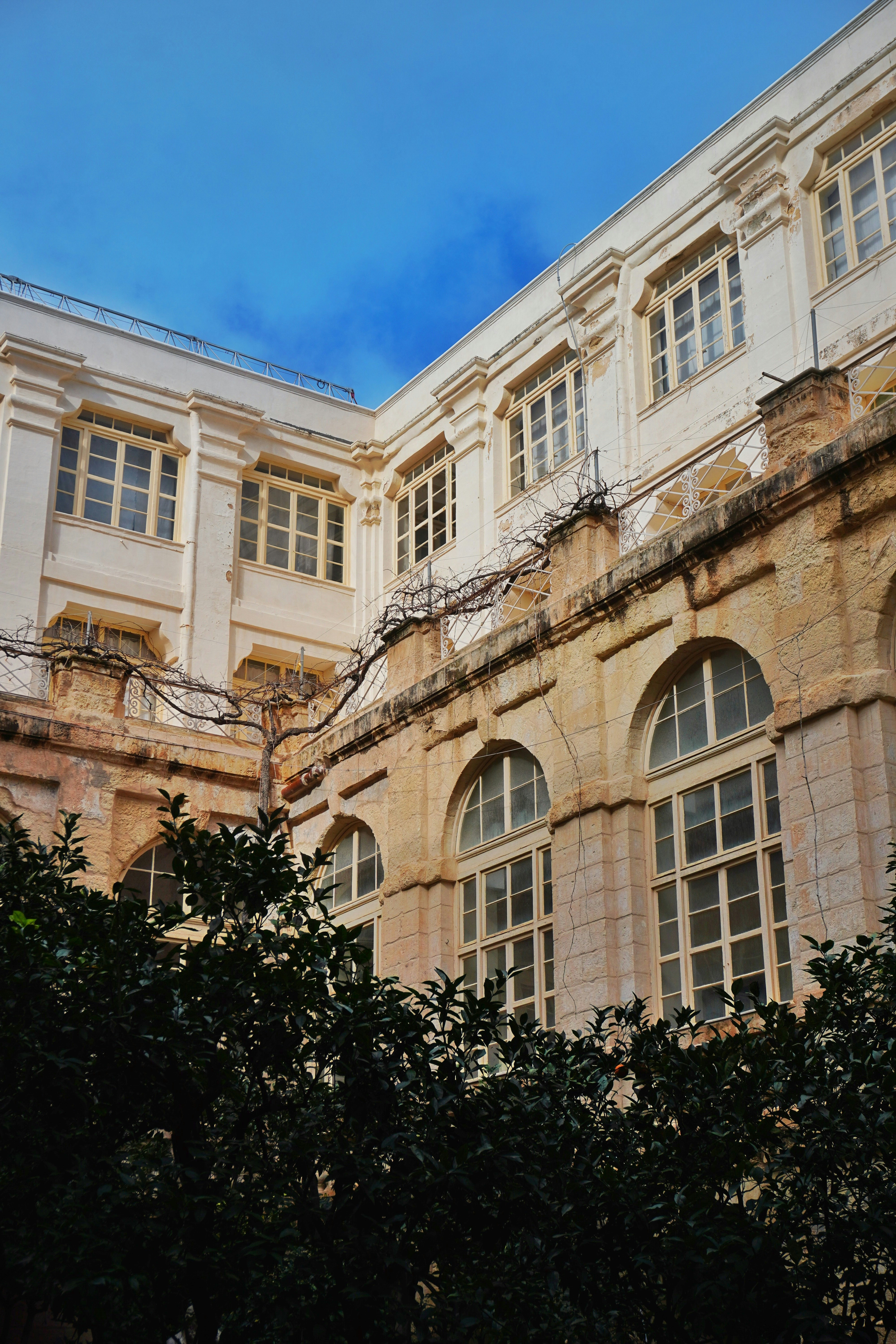 Sunlit Facade Above Shadows: Historic Architecture in Clear Sky
