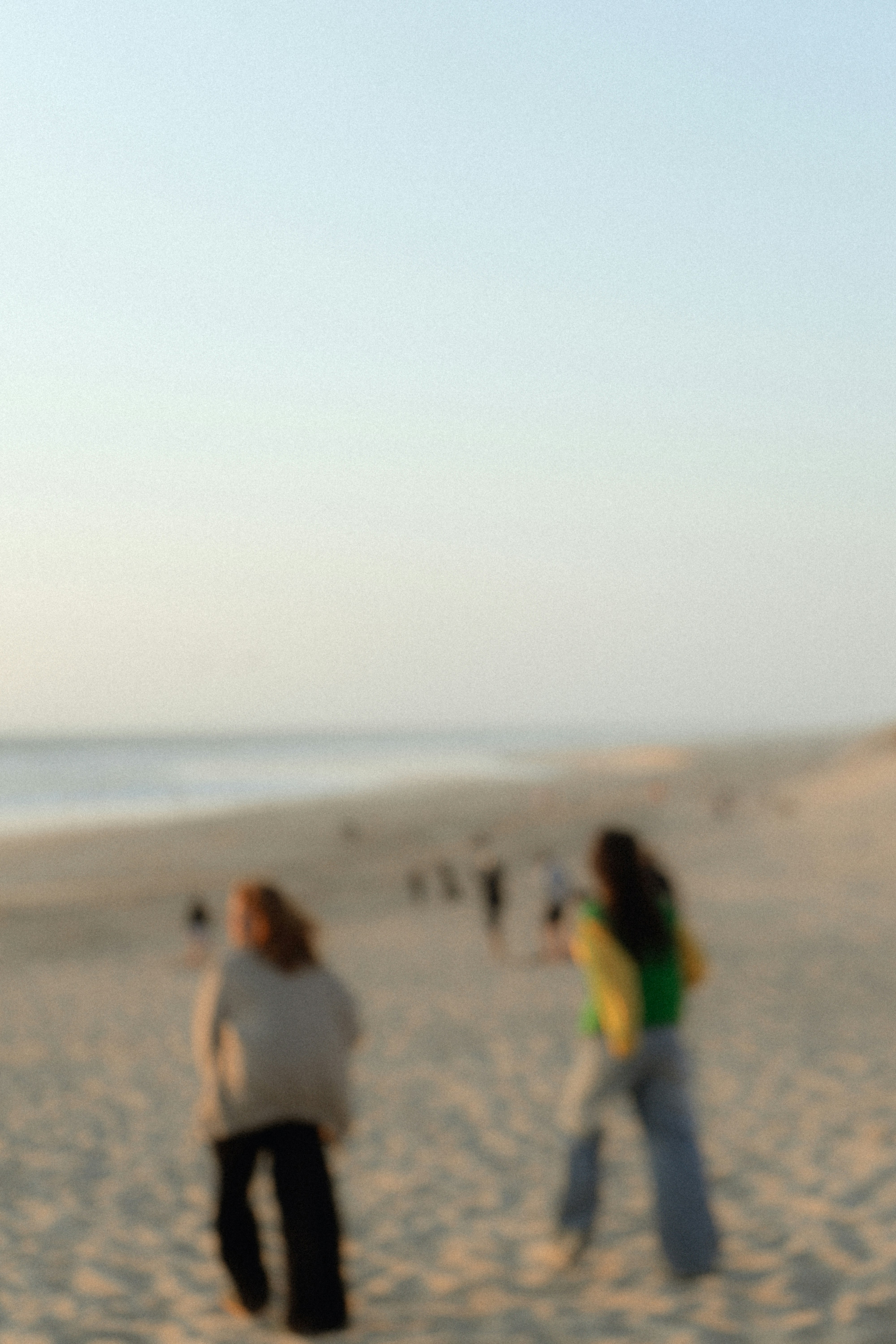 Blurry Beach Stroll: A Gentle Blur of People by the Sea