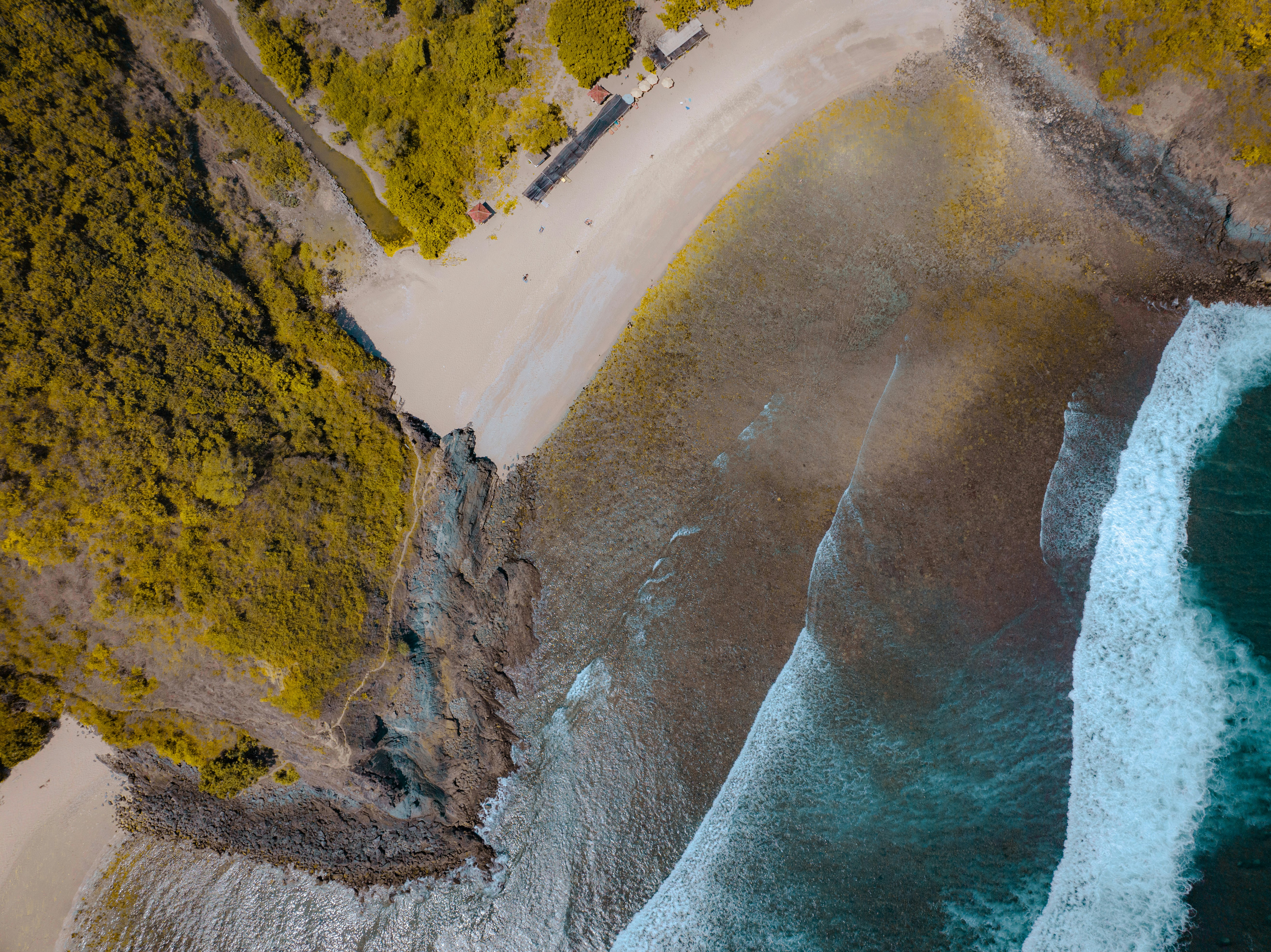 Coastal Cliff and Beach Aerial: Turquoise Tide Against Golden Shore
