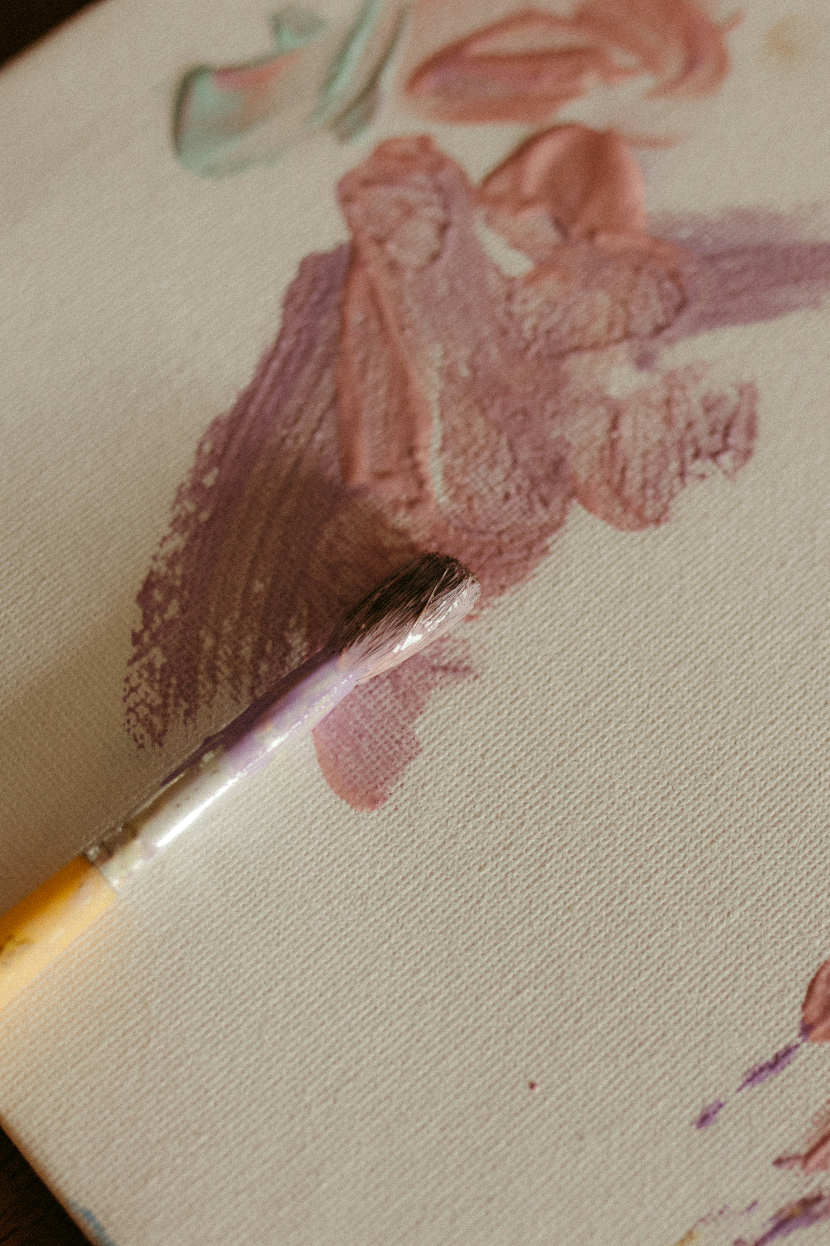 Olive-tinted strokes: a painter’s brush resting on a textured canvas