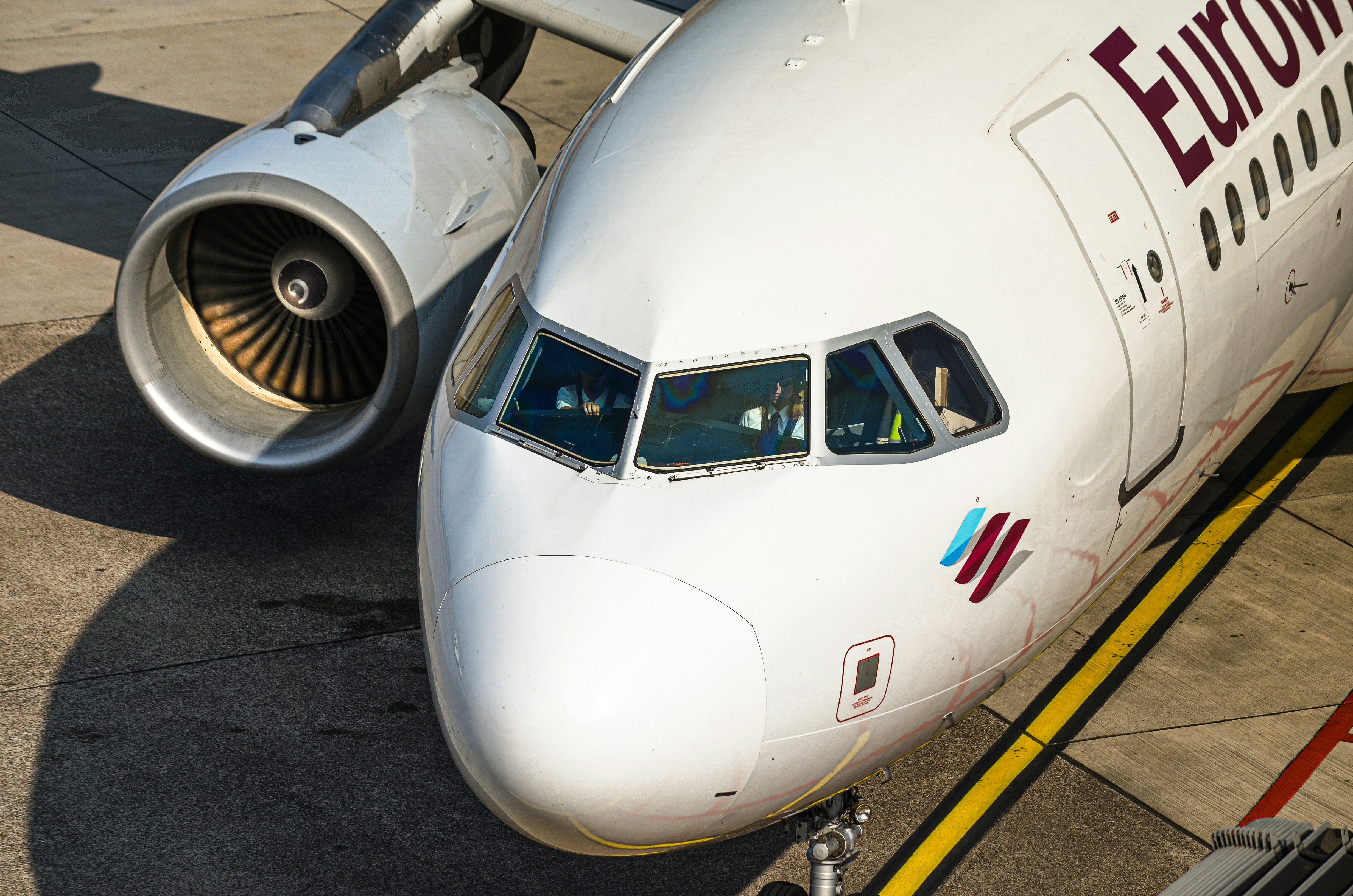 A forward-facing Airbus A320 at the gate, nose angled toward the camera