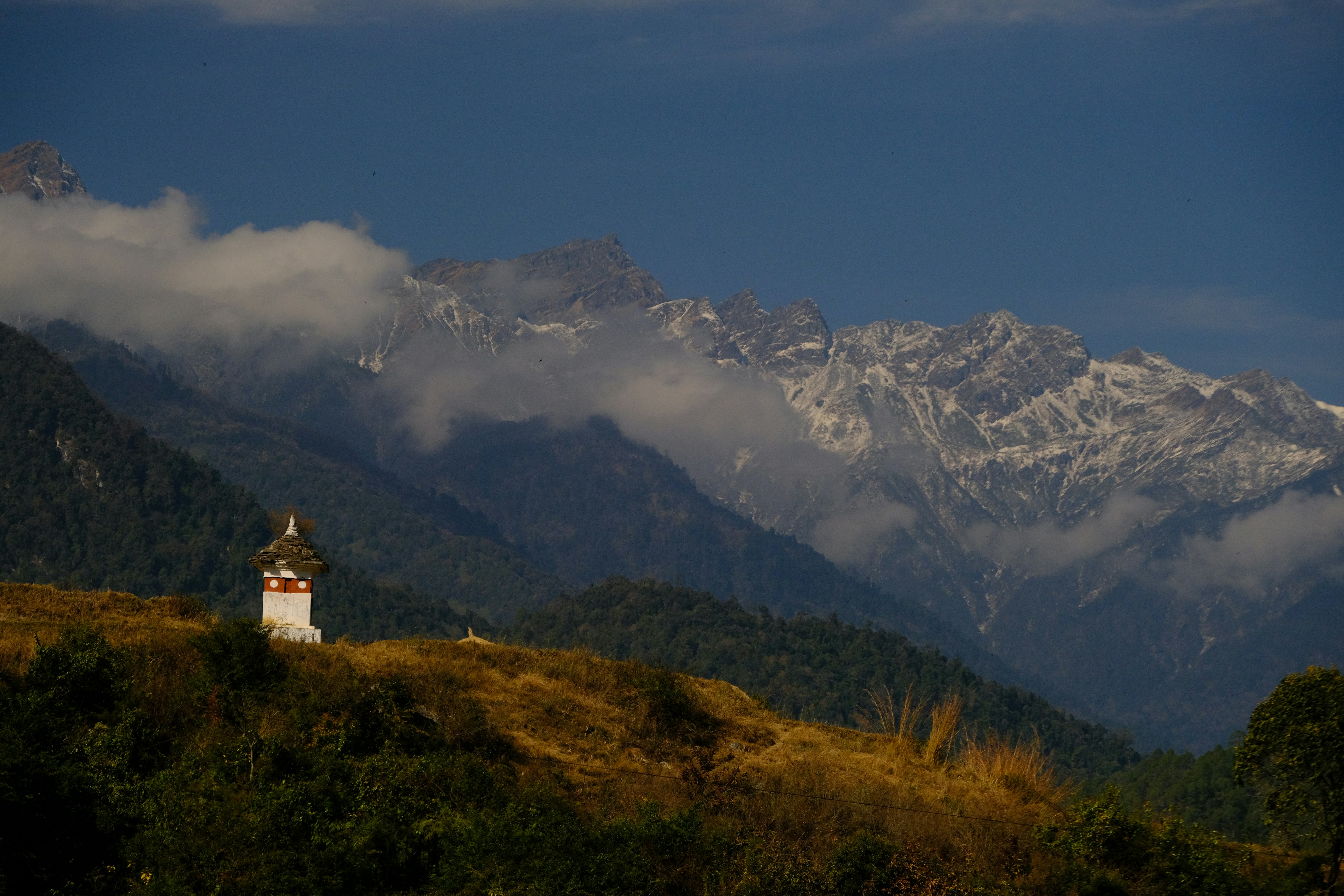 Lone Shrine on a Misty Ridge Beneath Alpine Peaks