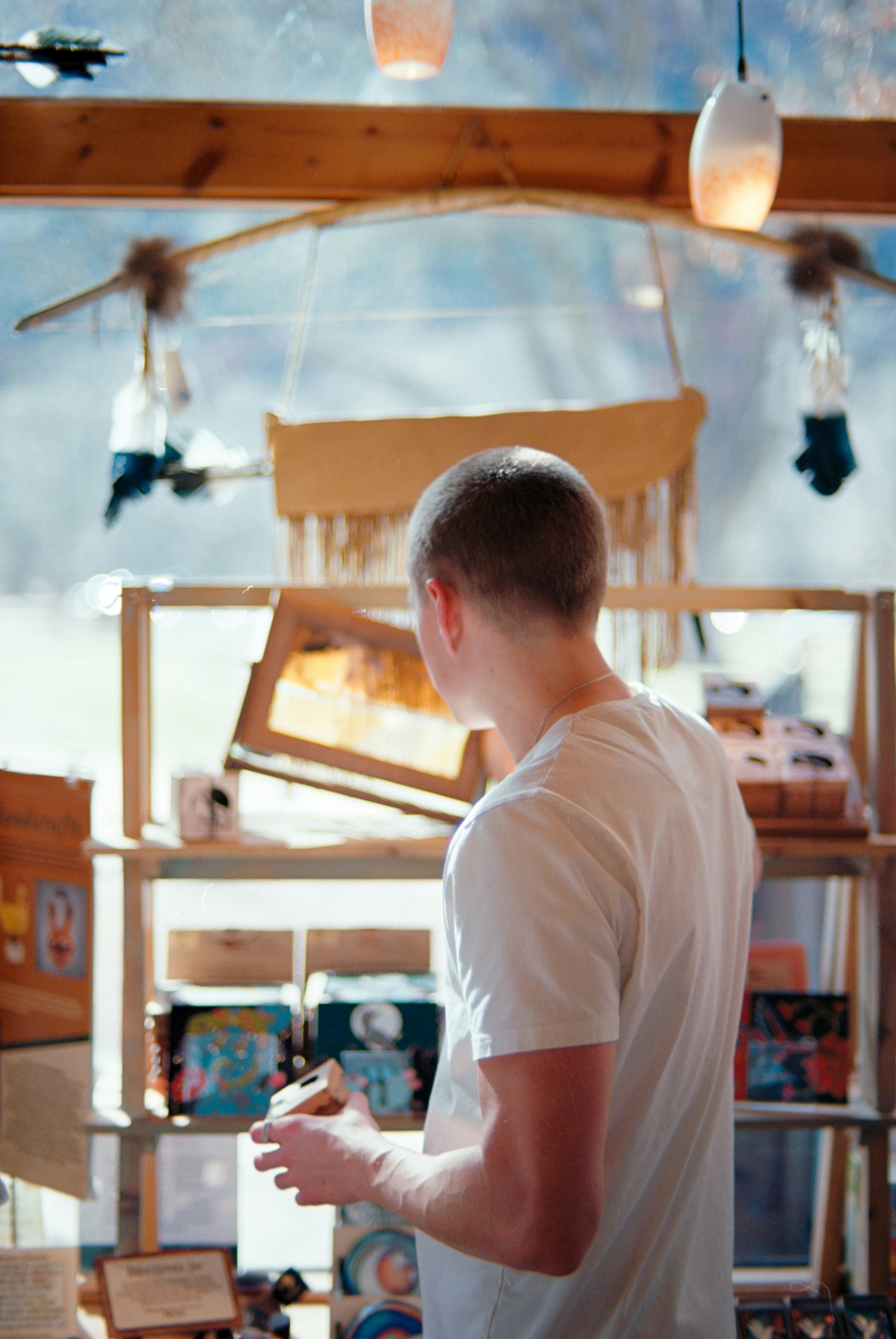 Breezy shop interior: a man in white t-shirt browses colorful decks of cards