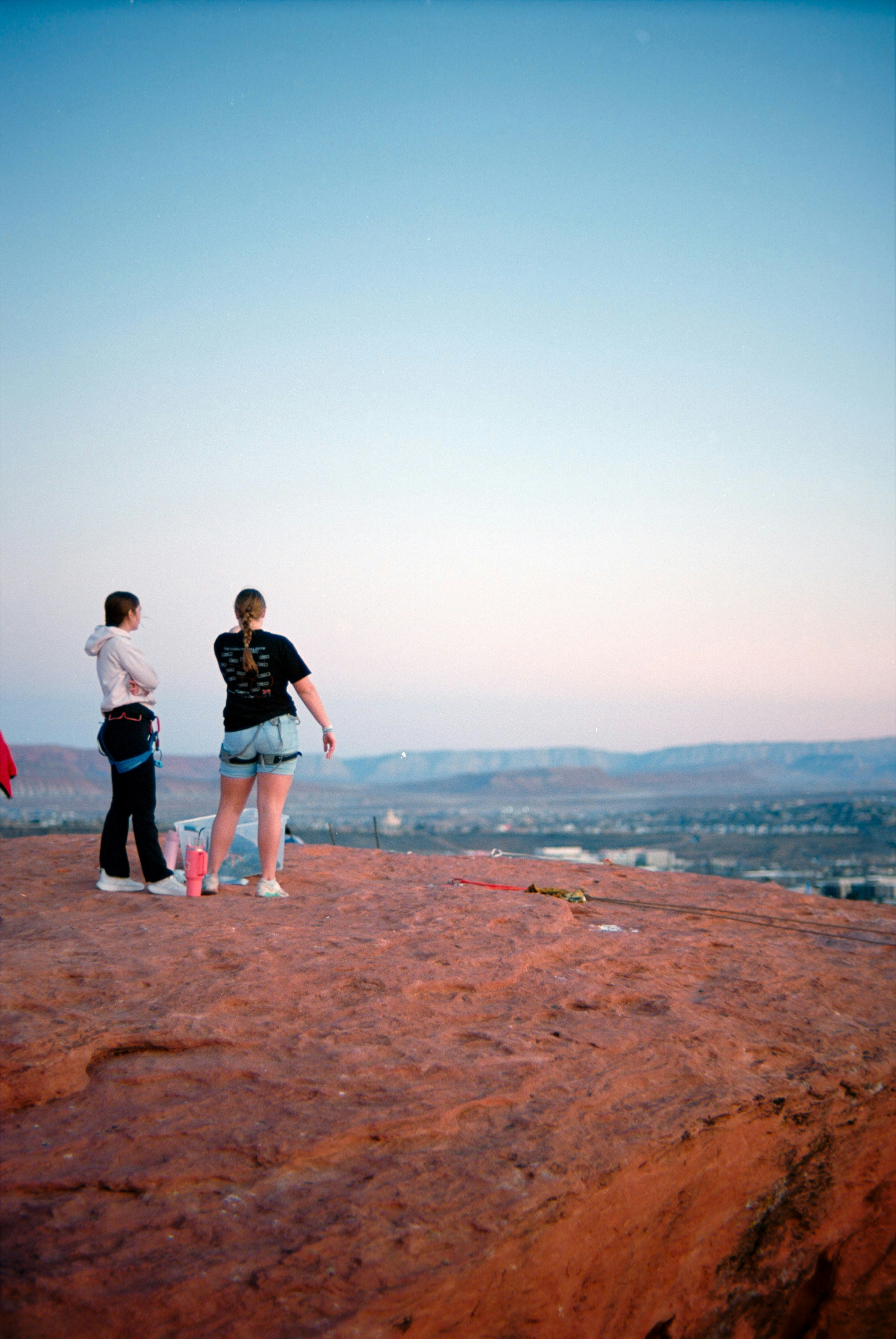 Group of hikers at sunset overlook on a red rock cliff
