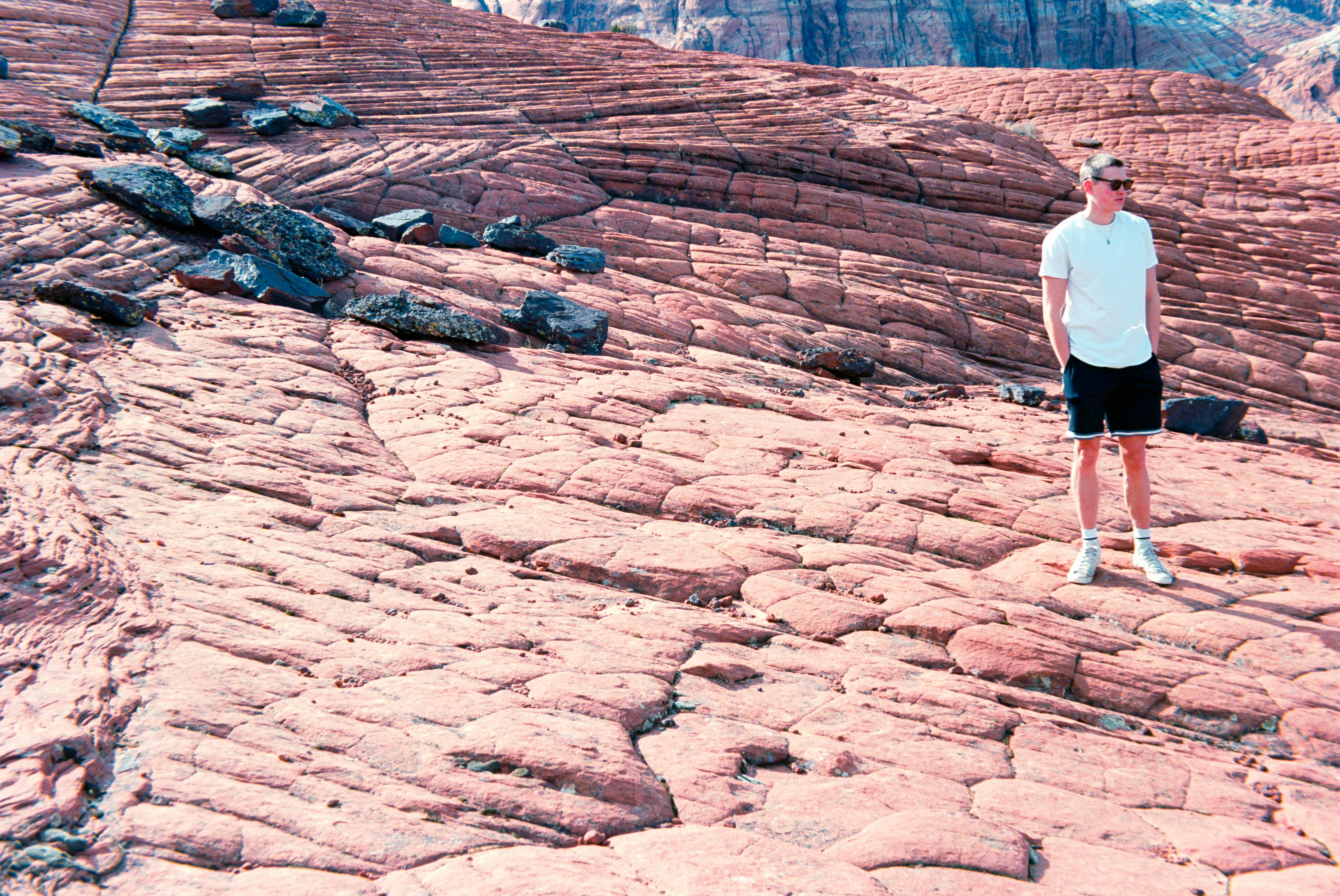 Red Rock Silhouette: Man in White T-shirt on Weathered Terrain