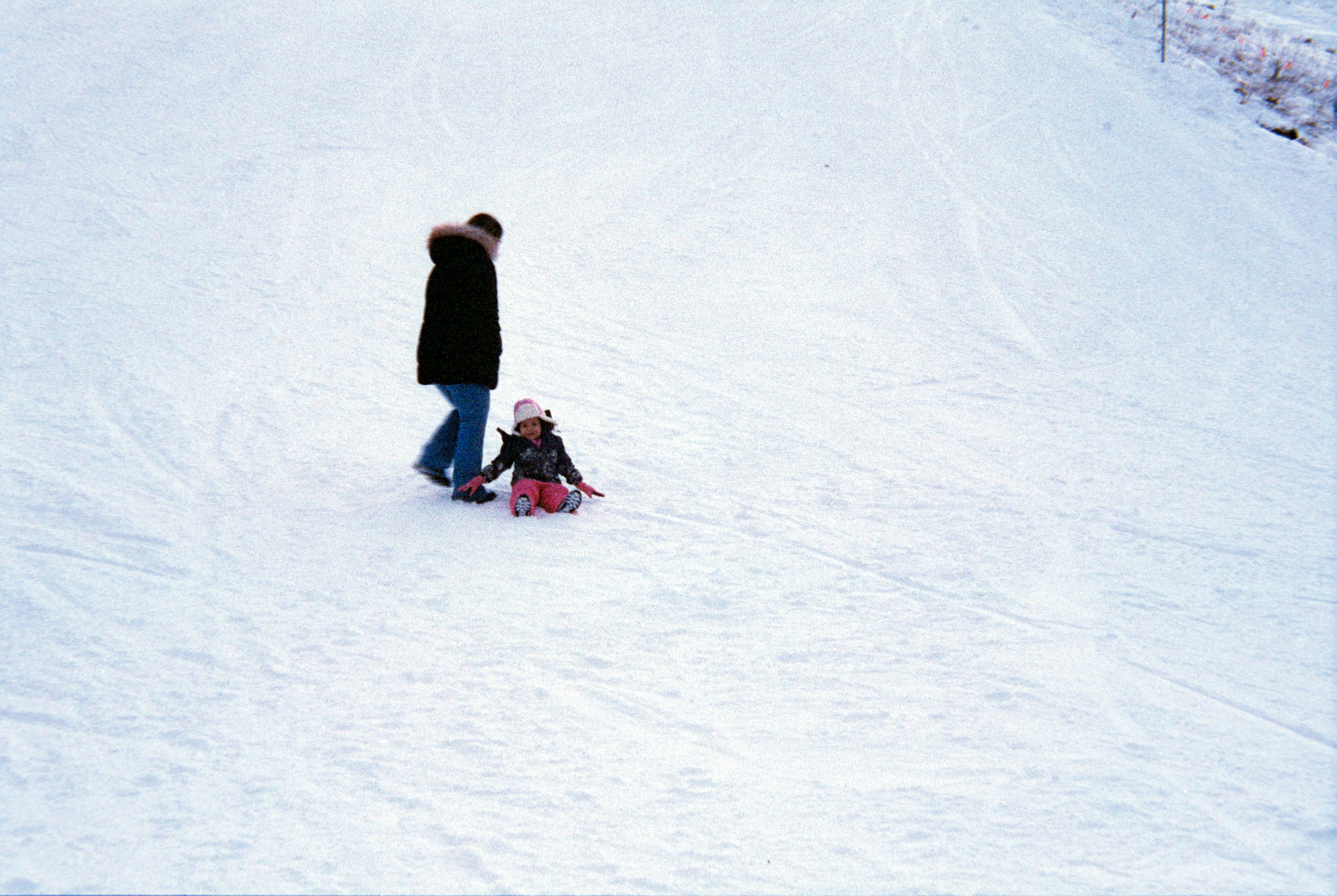 Snowbound Moment: A Caregiver Guides a Small Skier Down the Gentle Slope