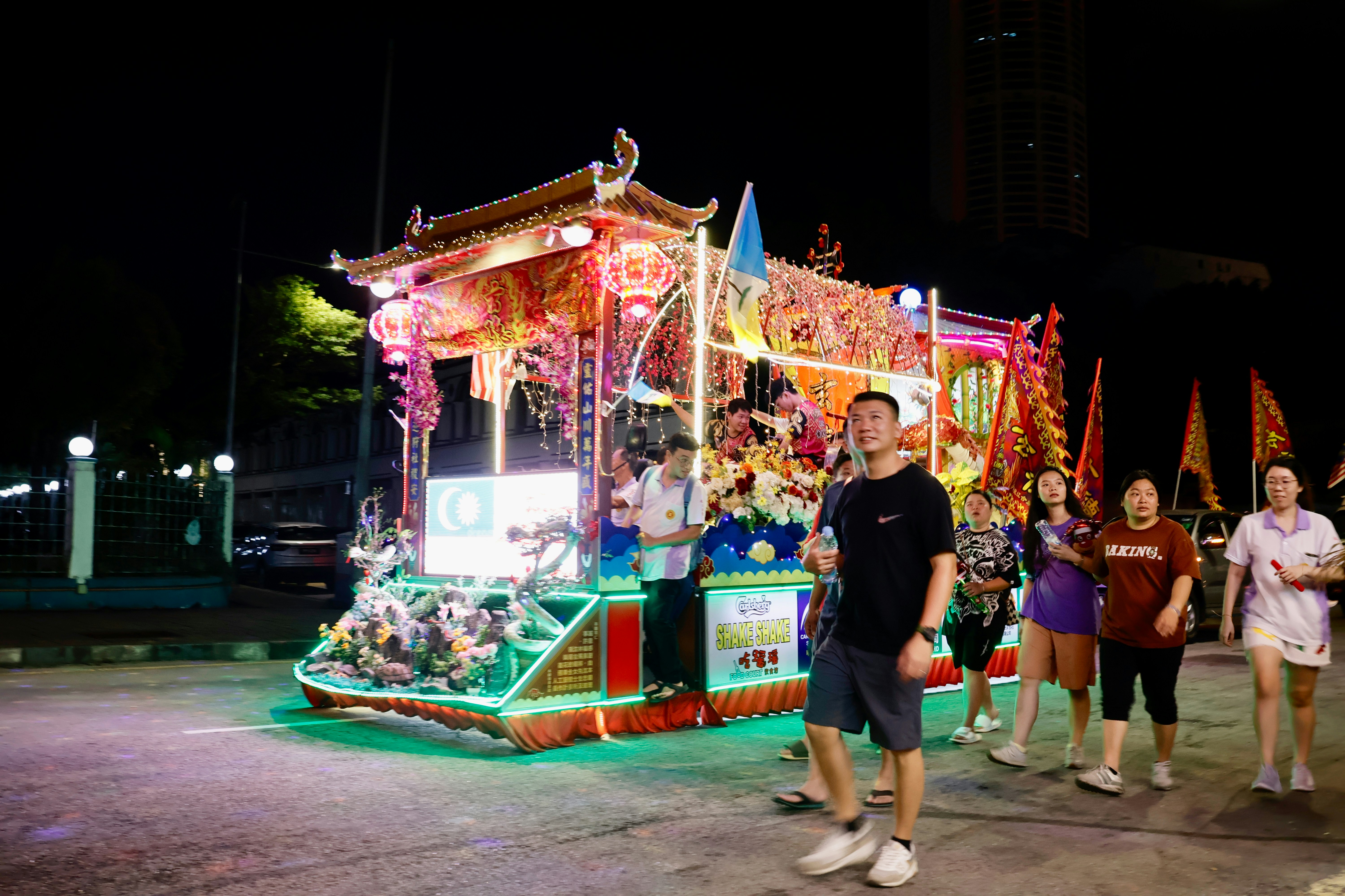 Night Parade Carriage: Illuminated Ornate Floats and Strolling Crowd