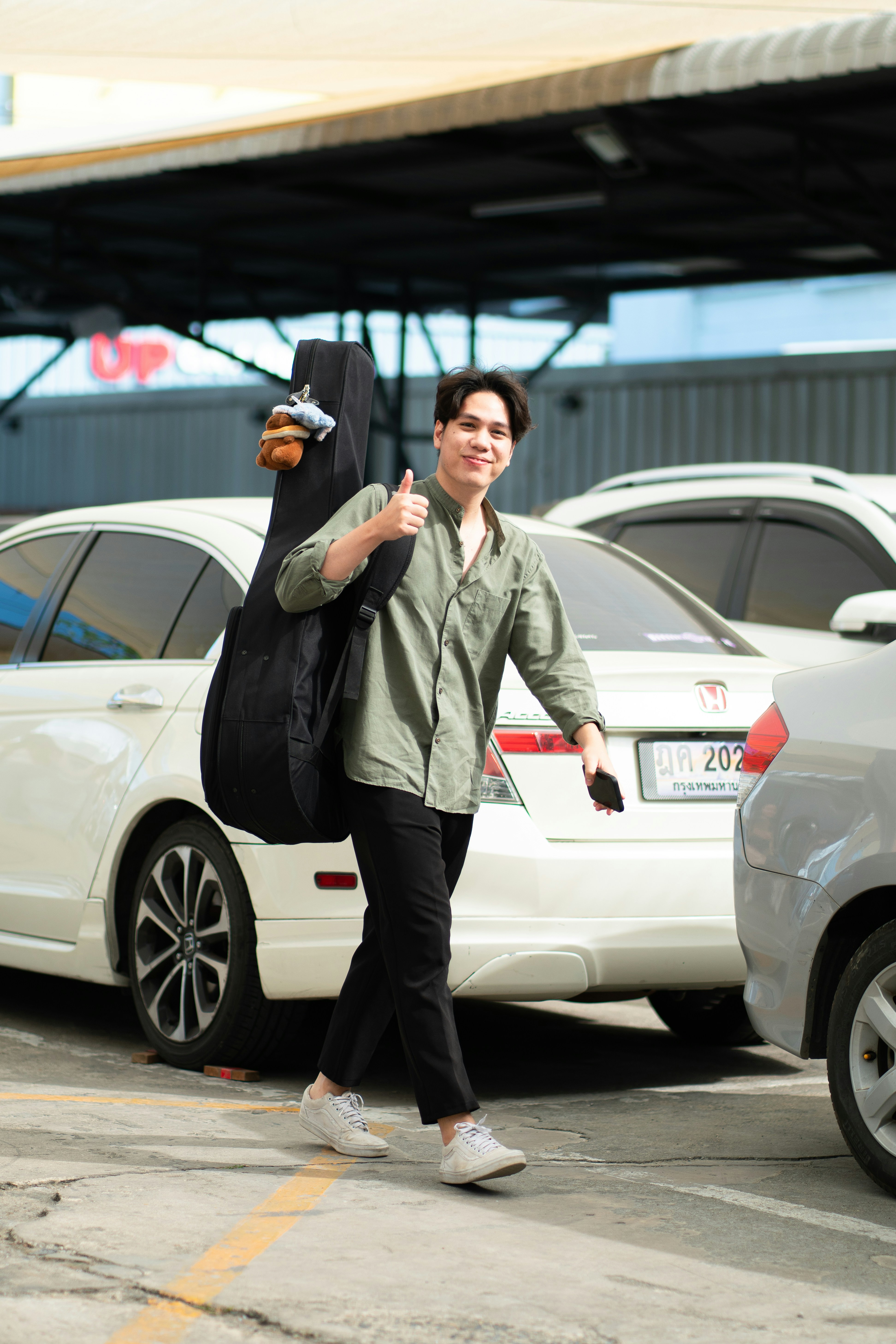 Thumbs Up and Guitar Case: A Street musician heads to the next gig