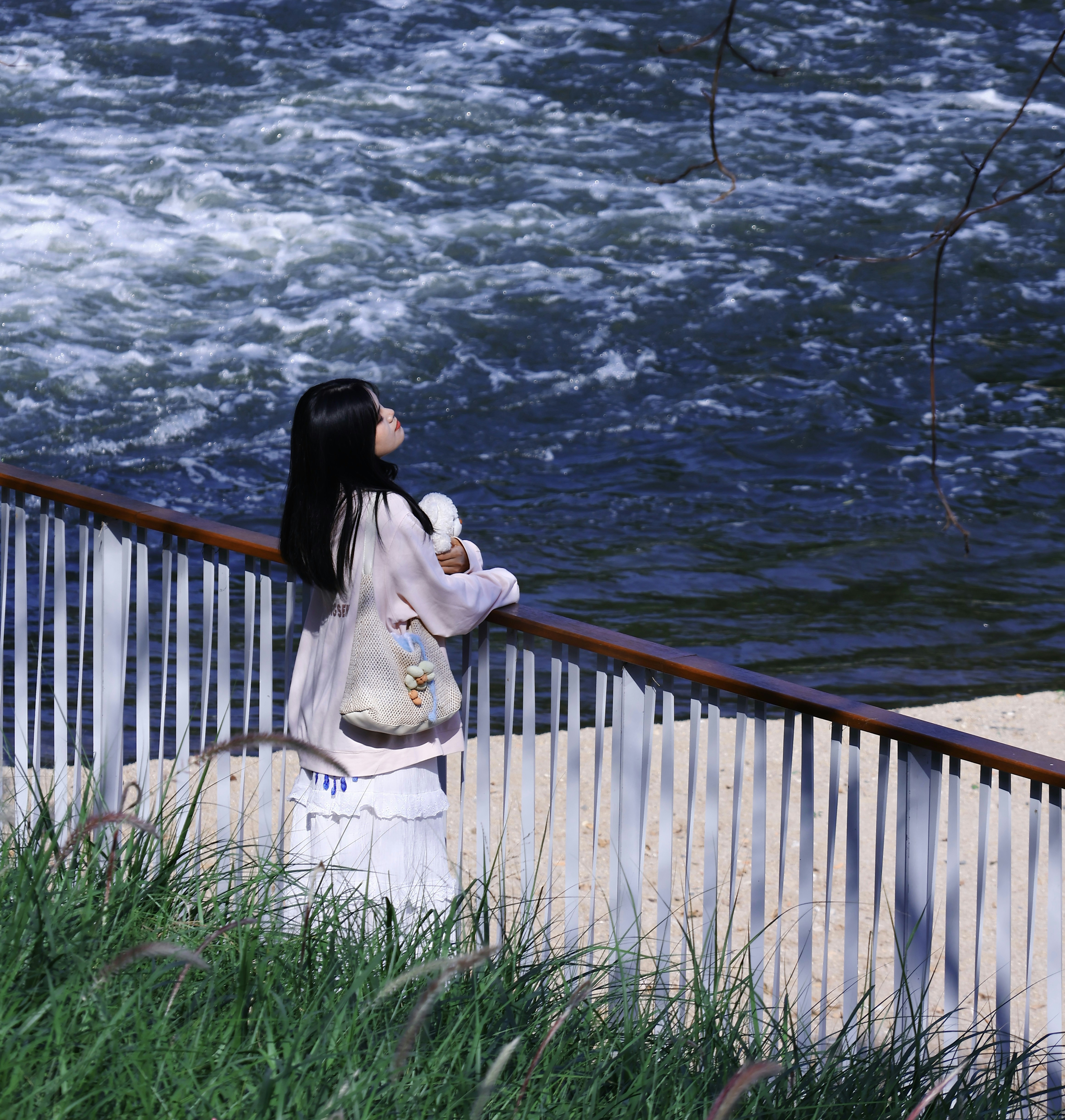 Quiet Resolve by the Water: A Woman with a Bag on a Railing