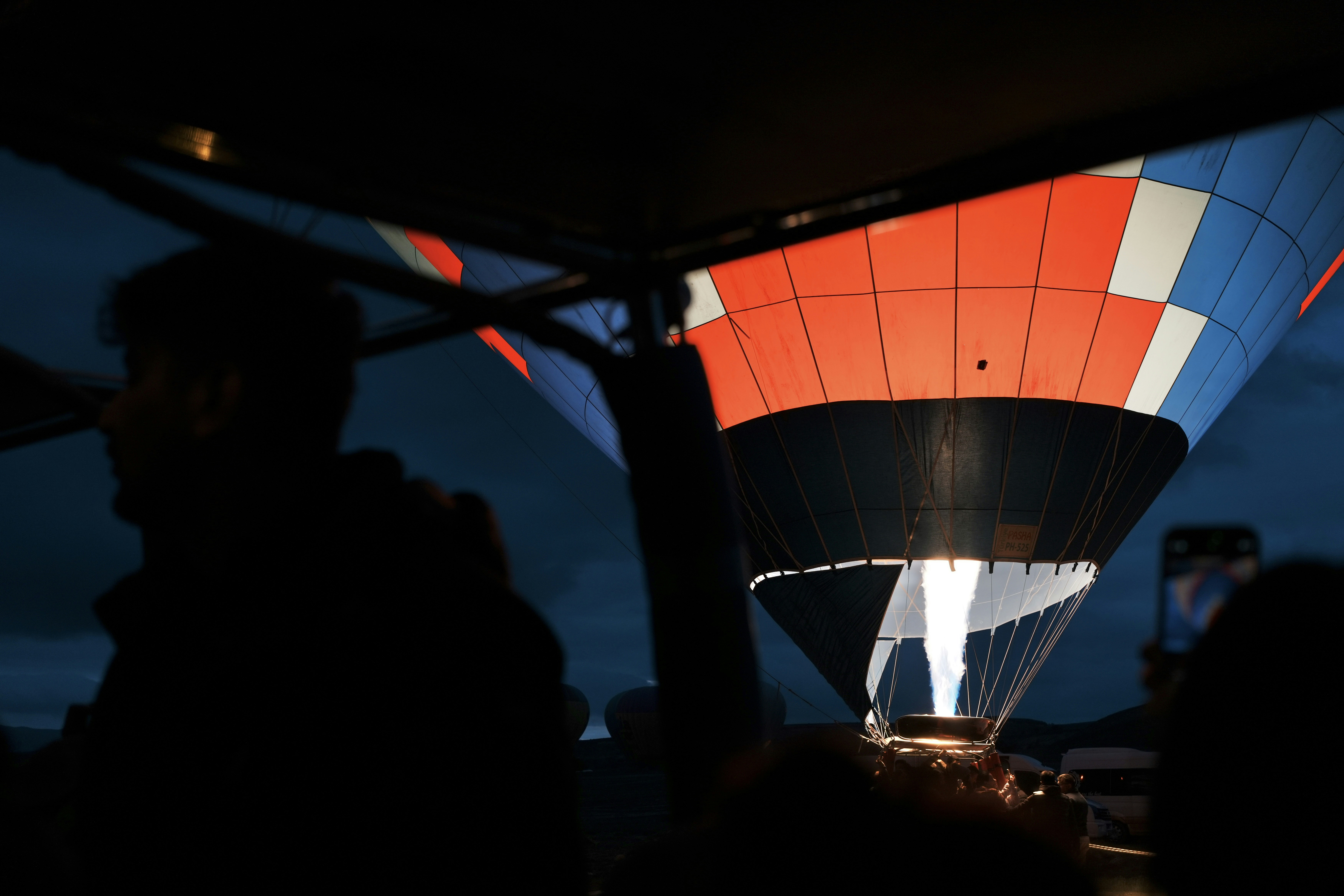 Emerald and Crimson: A Balloon’s Flame Illuminates the Darkened Deck