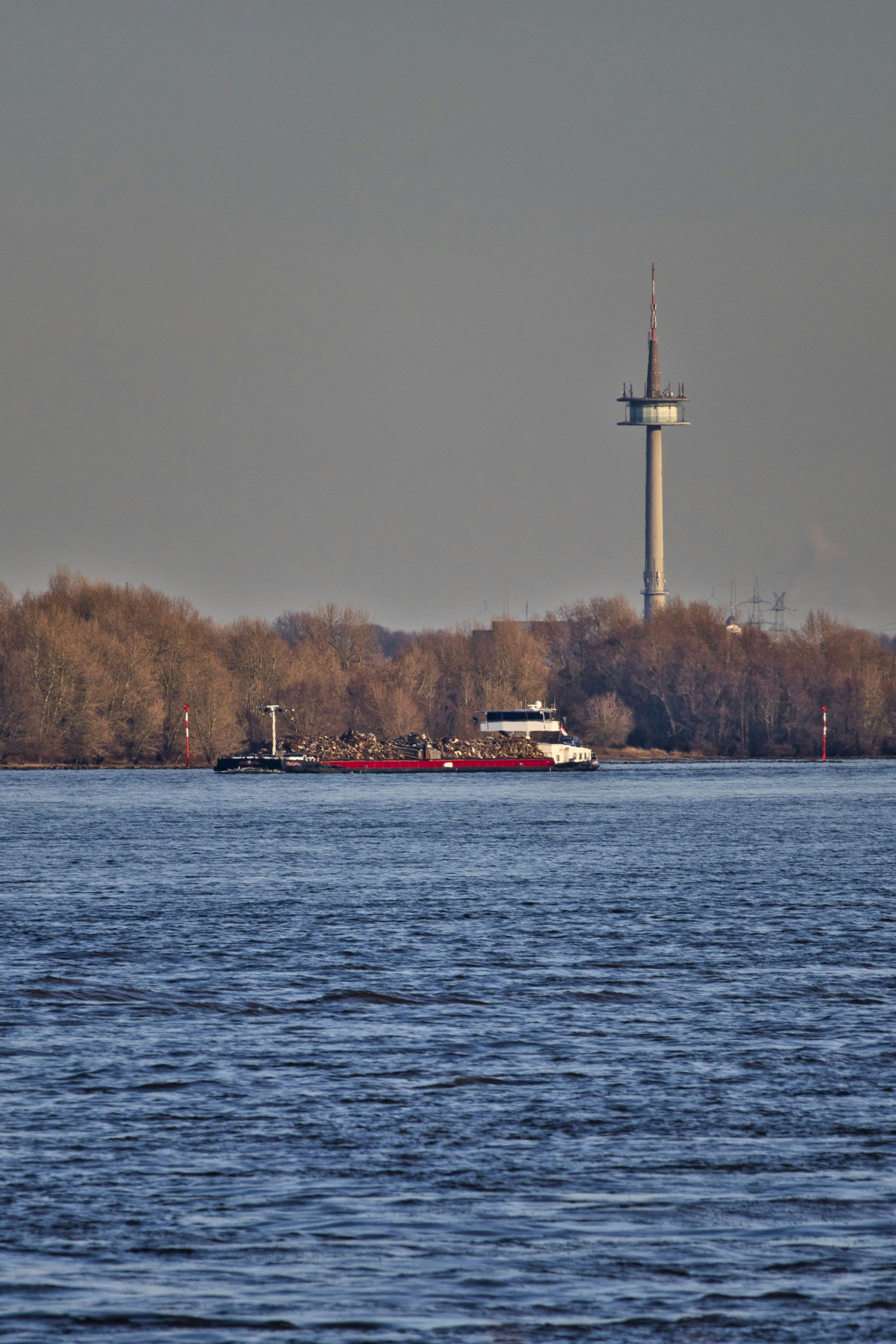 Toward the Horizon: A Ship and a Tower Silhouette Across Quiet Water