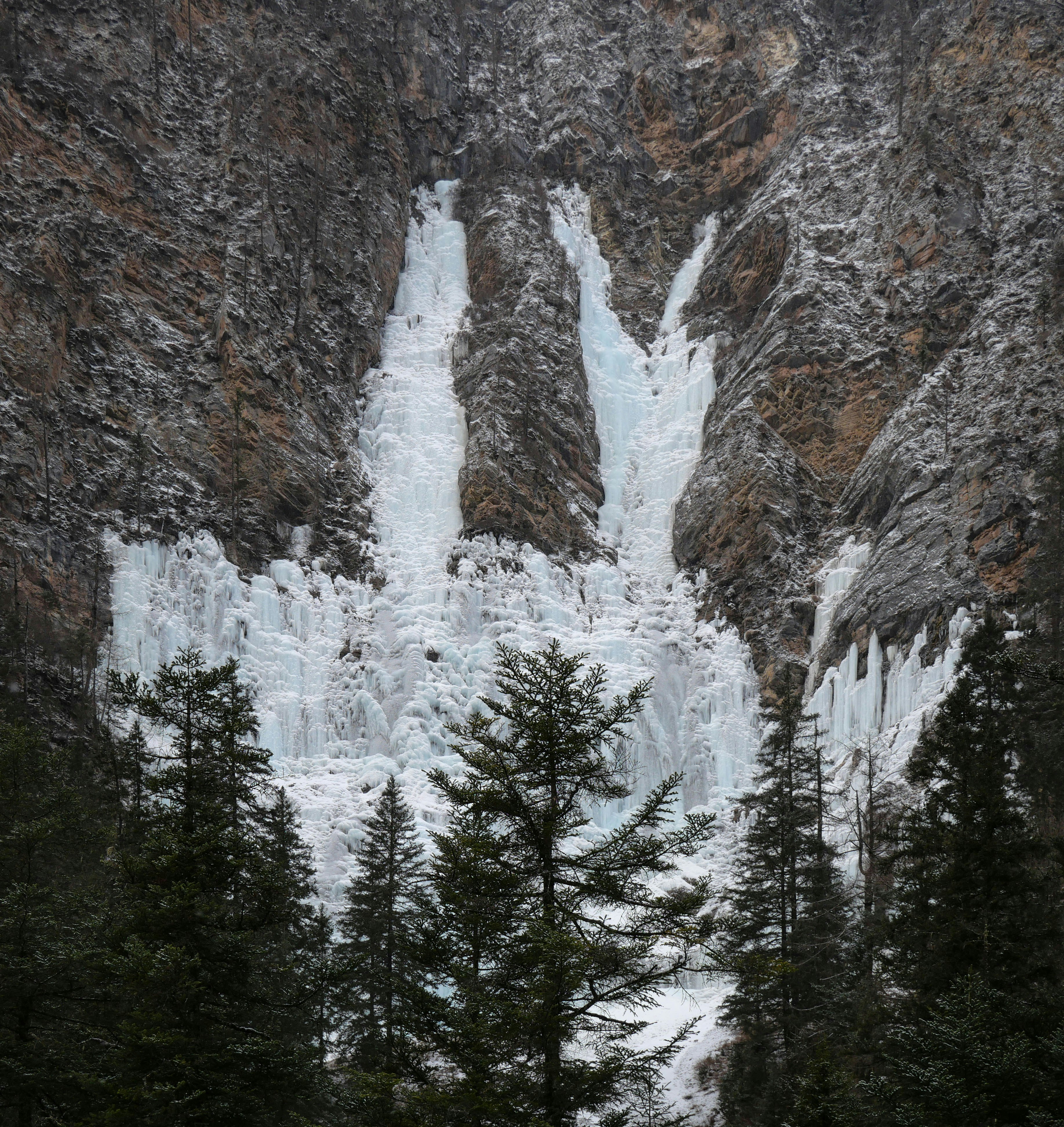 Frozen waterfalls cascade down a rocky mountainside
