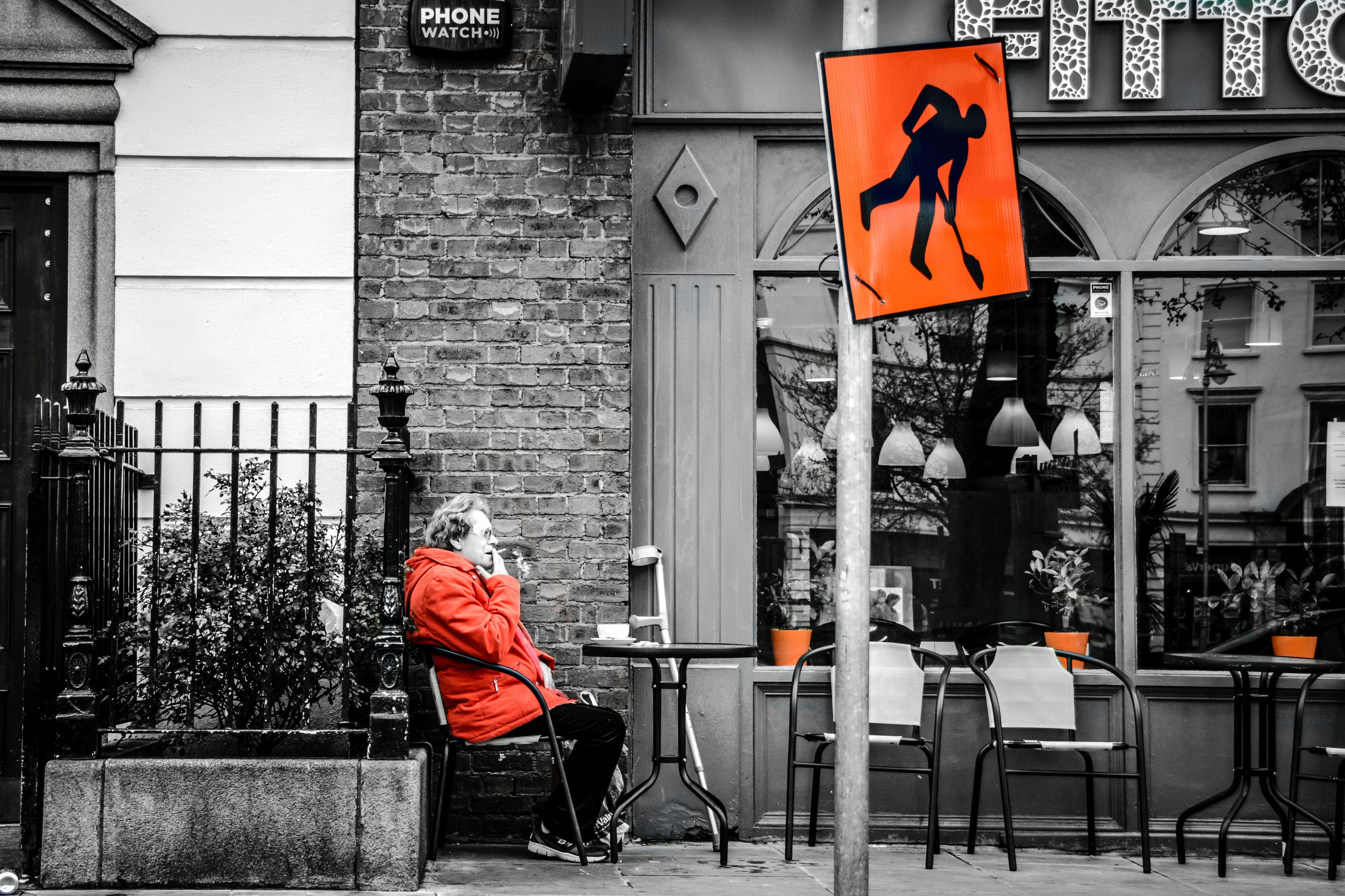 Red Coat, Quiet Corner: A Man in Solitude by the Café