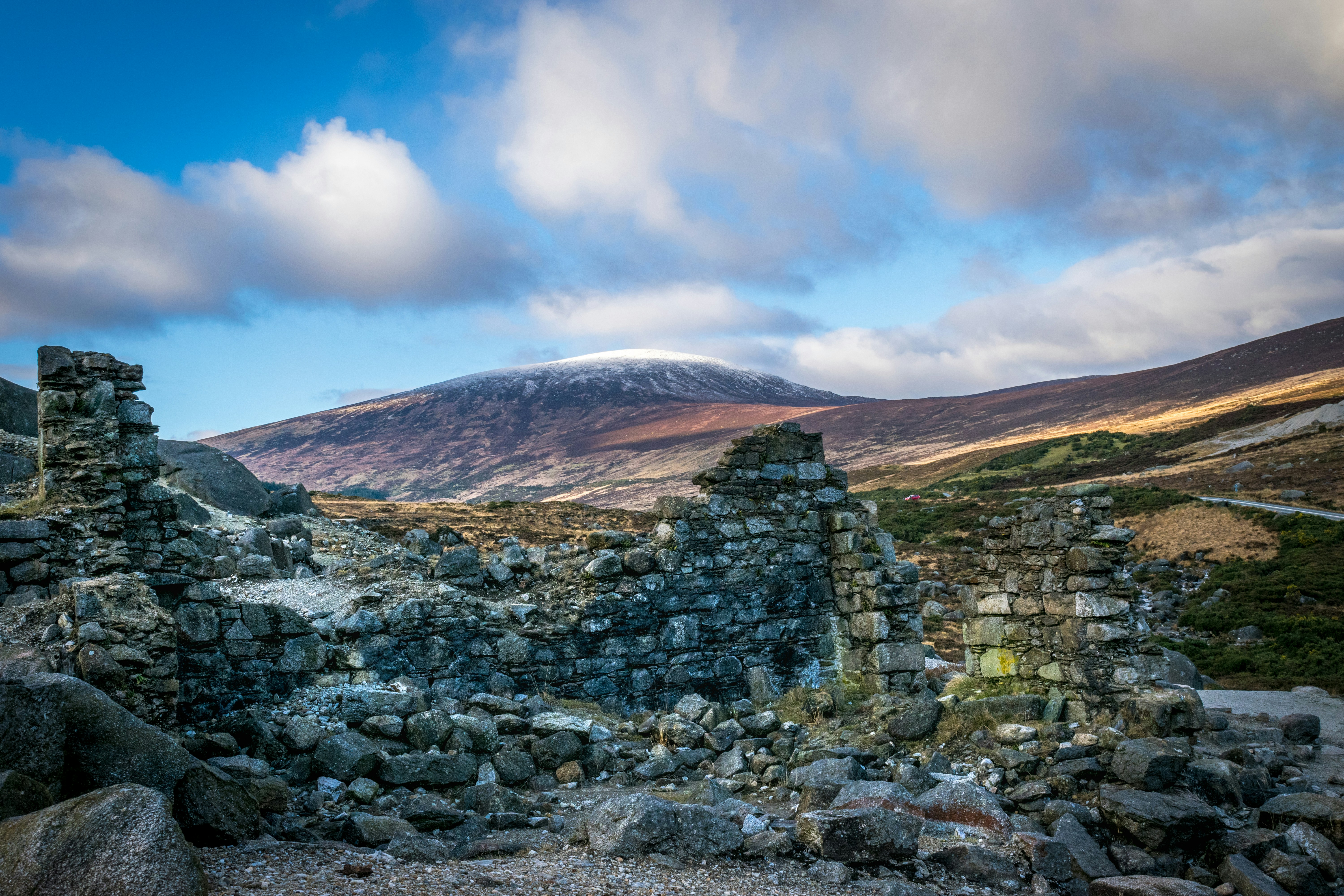 Stone Ruins and a Snow-Capped Ridge Under Wide Sky