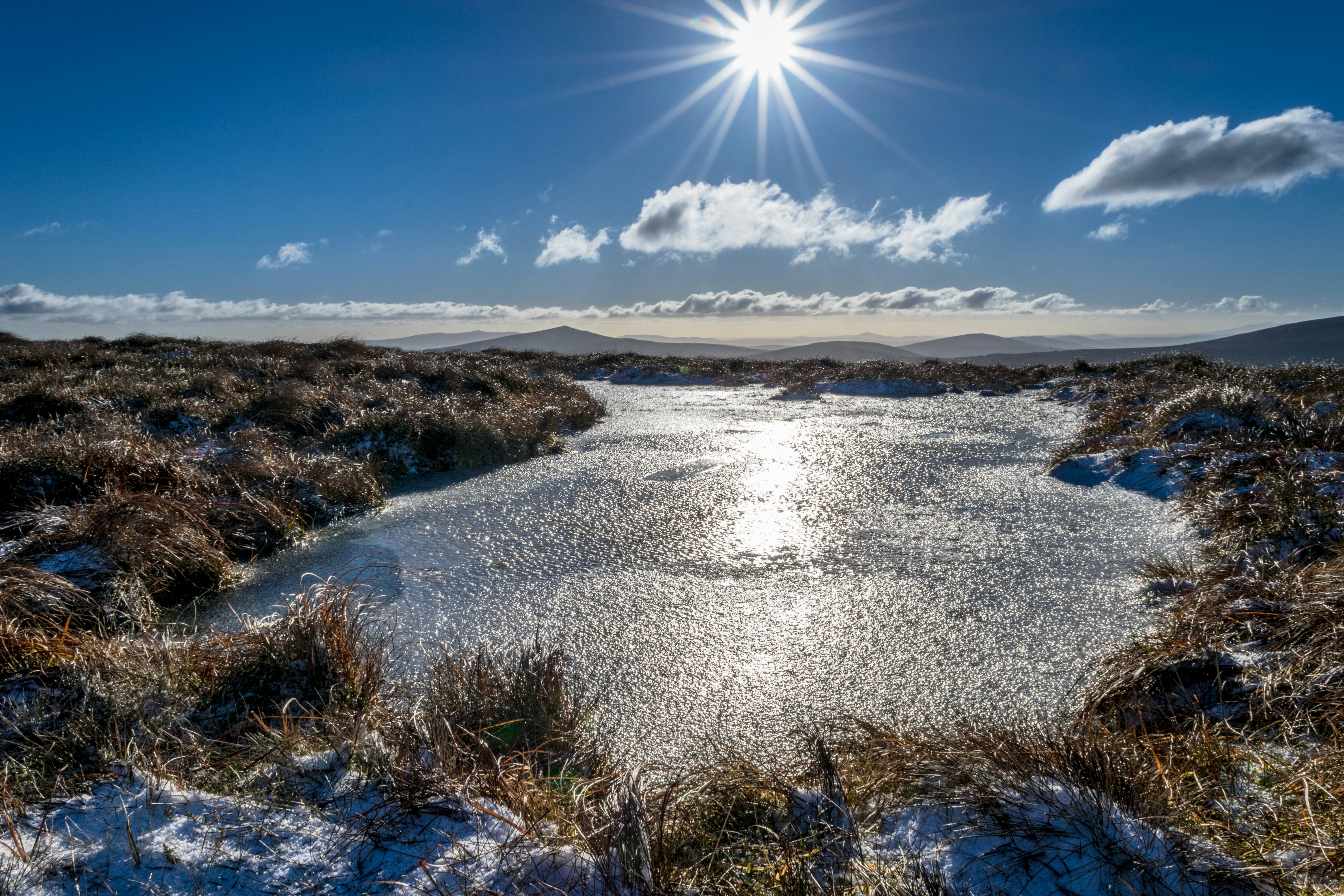 Sunlit Tundra Stream: A Glimmering Path Through Winter’s Quiet Moor