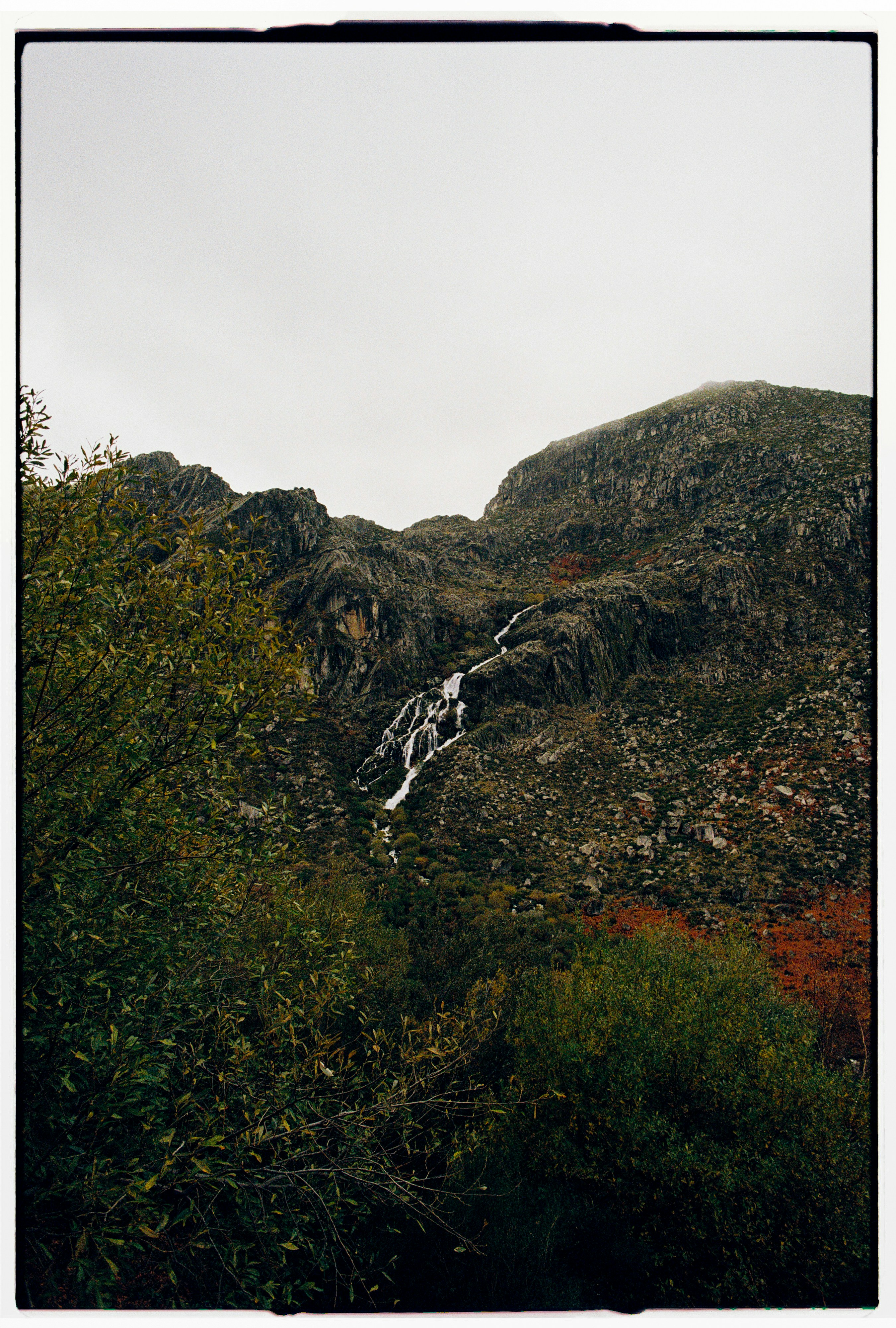 White-water cascade carving a line down rugged mountain face