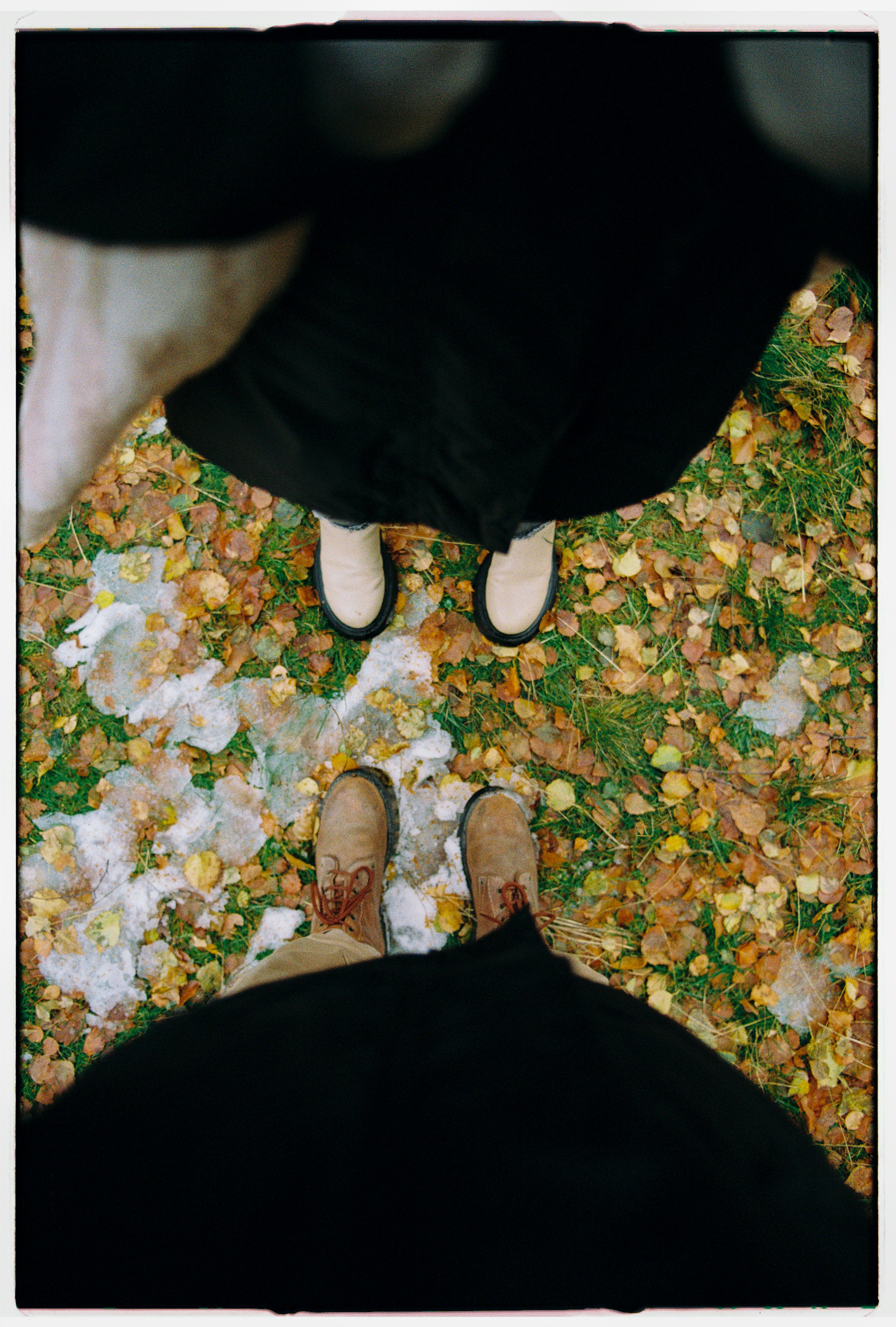 Footsteps in Autumn Snow: A Duo of Boots and Leaves