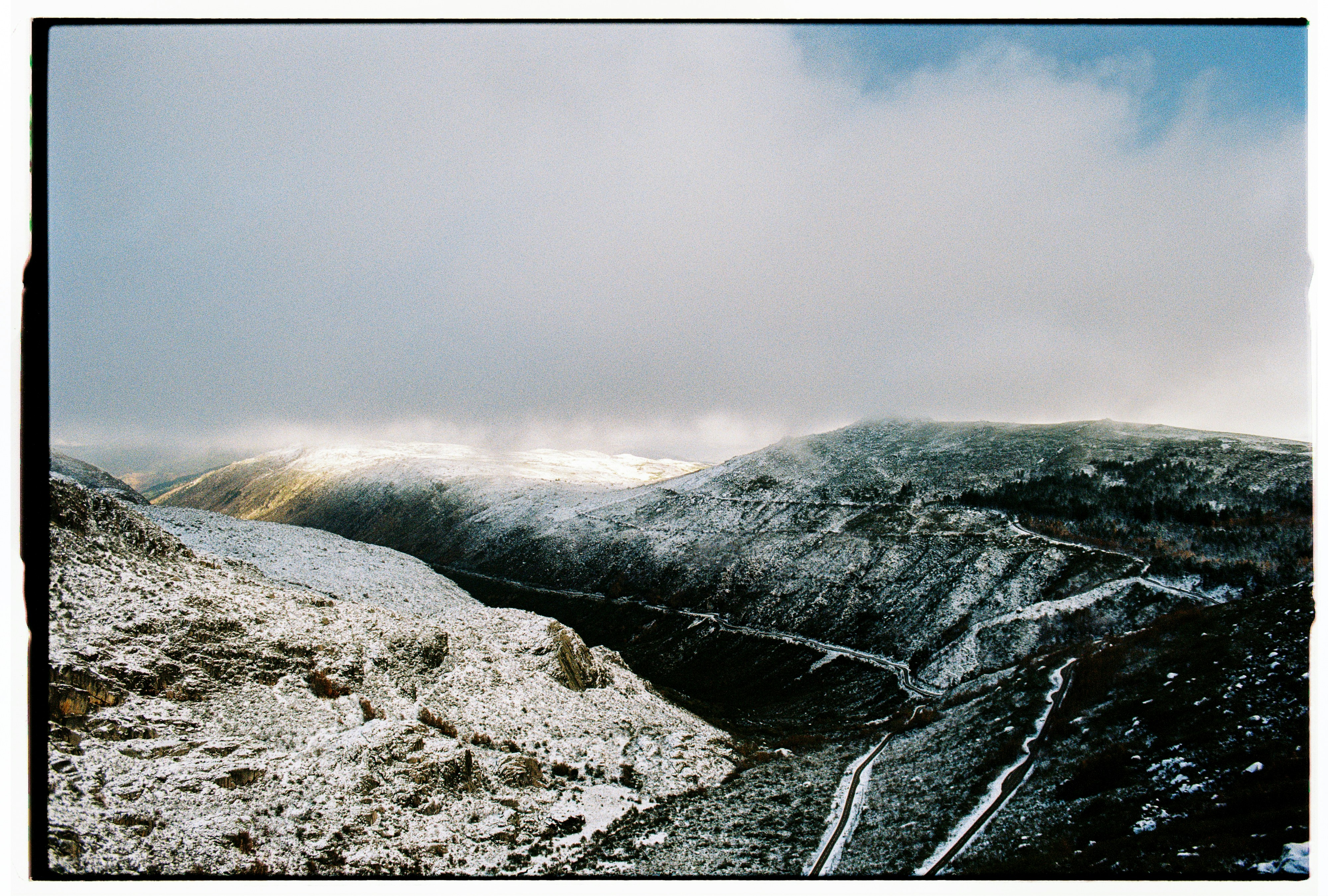 Snow-kissed Ridge Route Under Cloudbreak