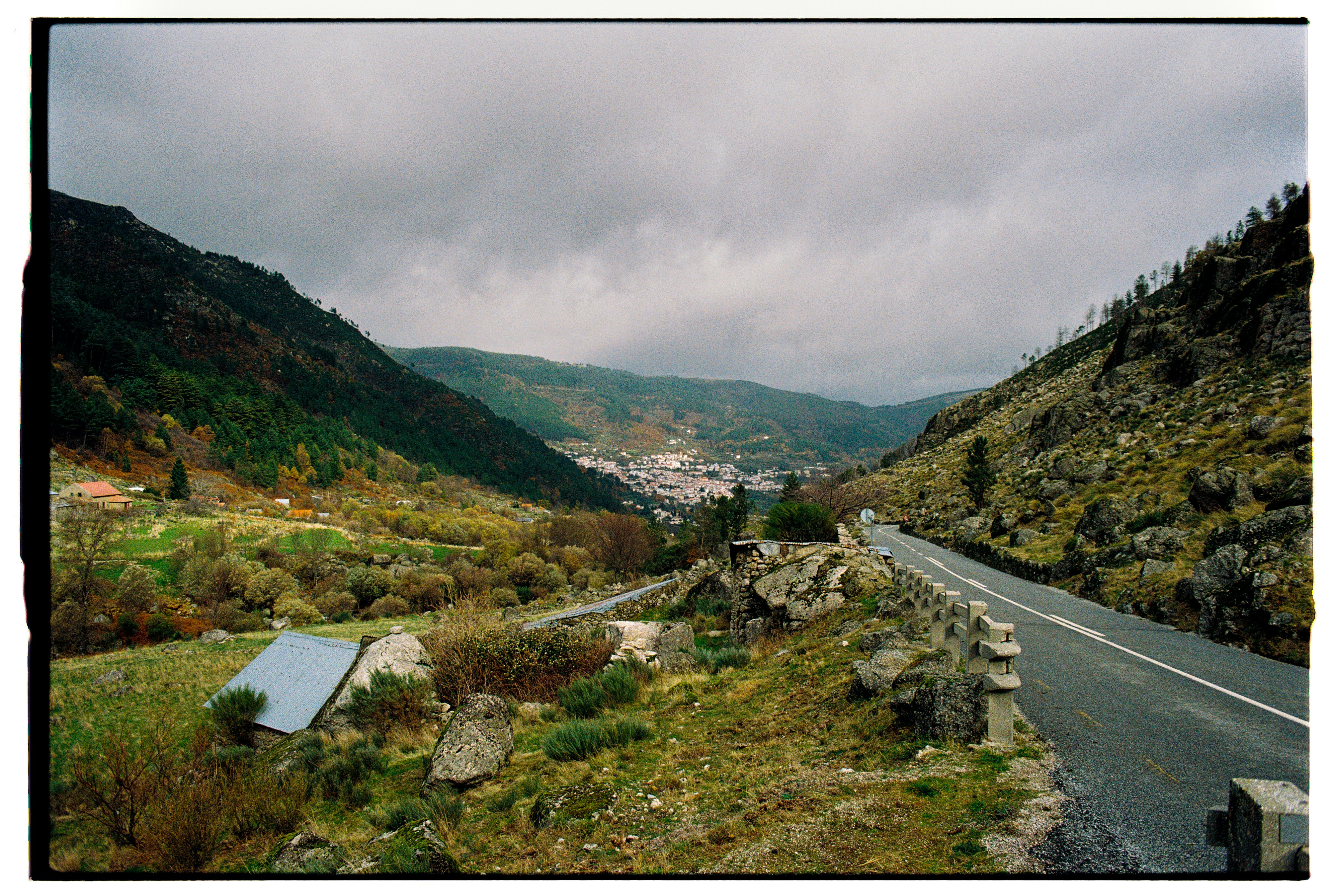  Valley Road to the Village: A Mountain Pass Framed by Stones and Sky