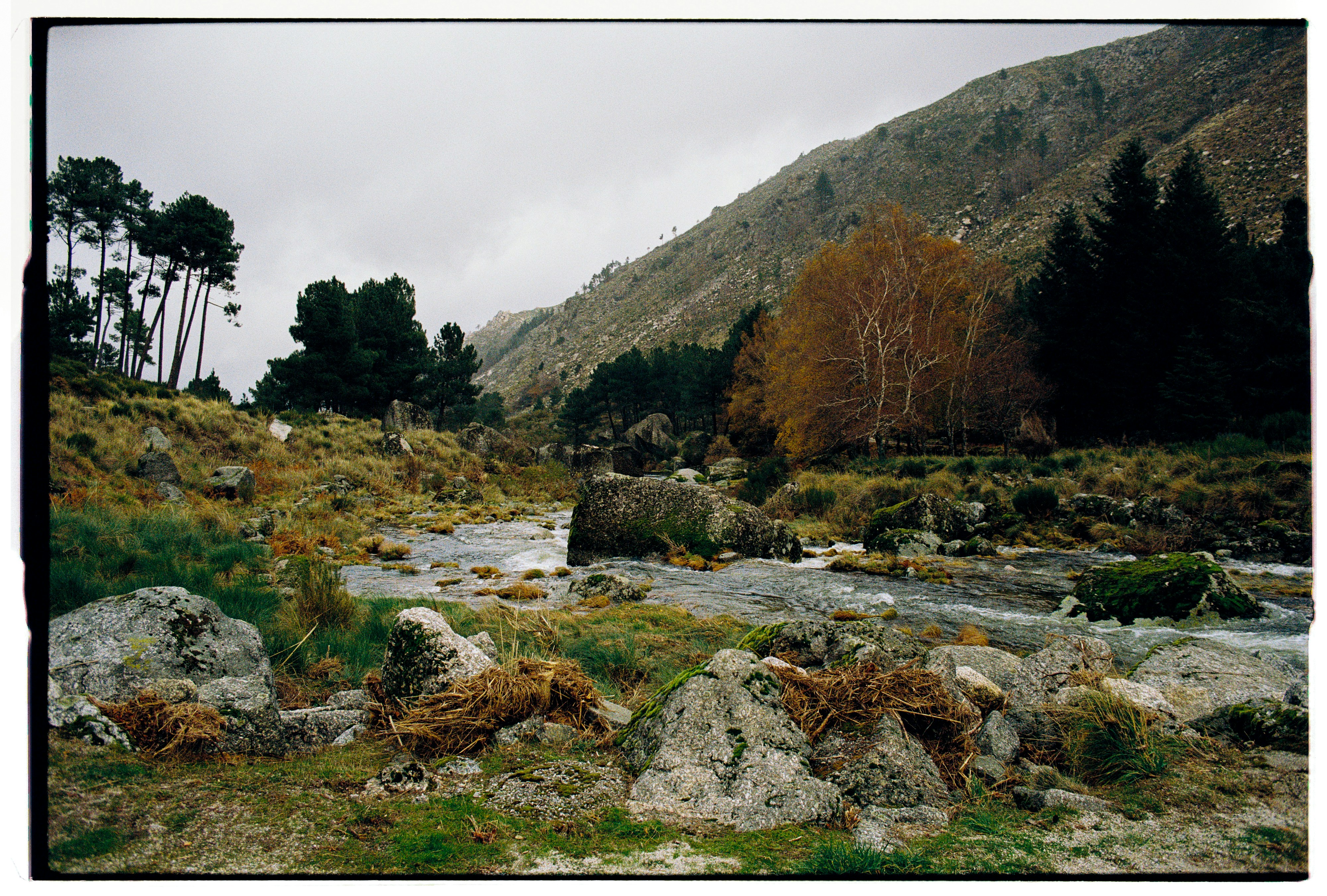 Rugged Riverbed Corridor under a Cloudy Shale Ridge