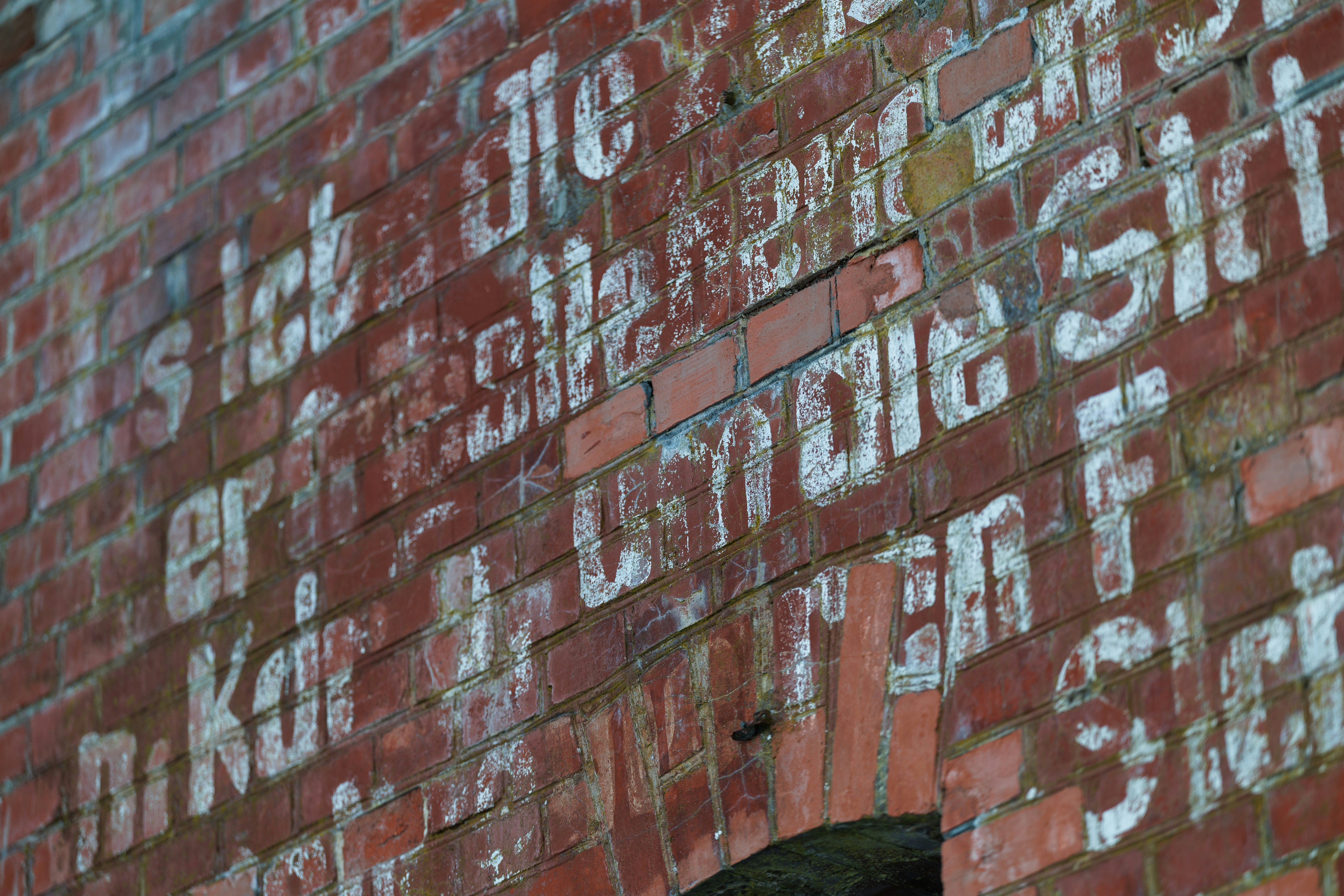Weathered brick arch with painted lettering