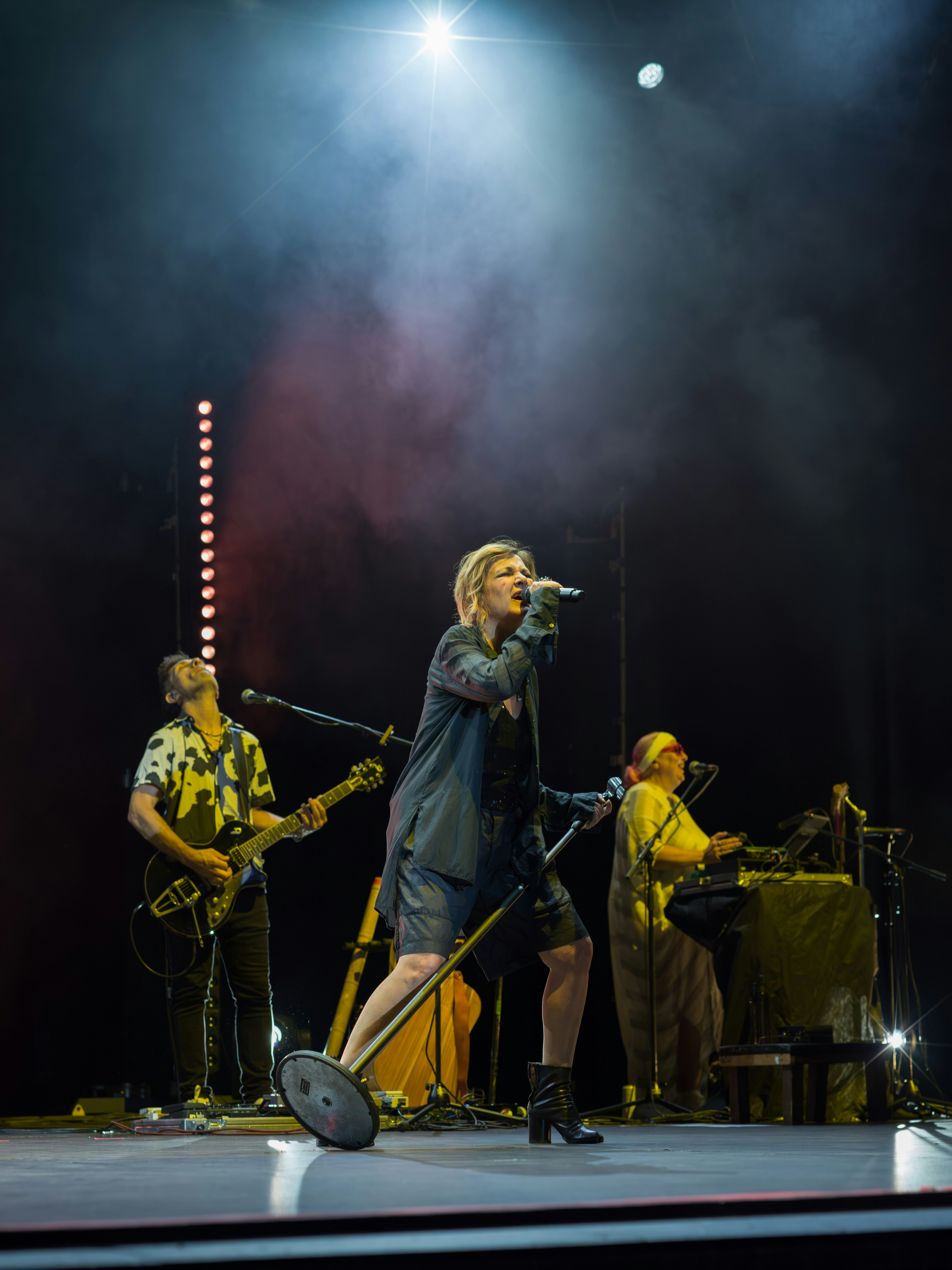 Center Stage in Neon Smoke: A Vocalist Leads with Guitars and Keys